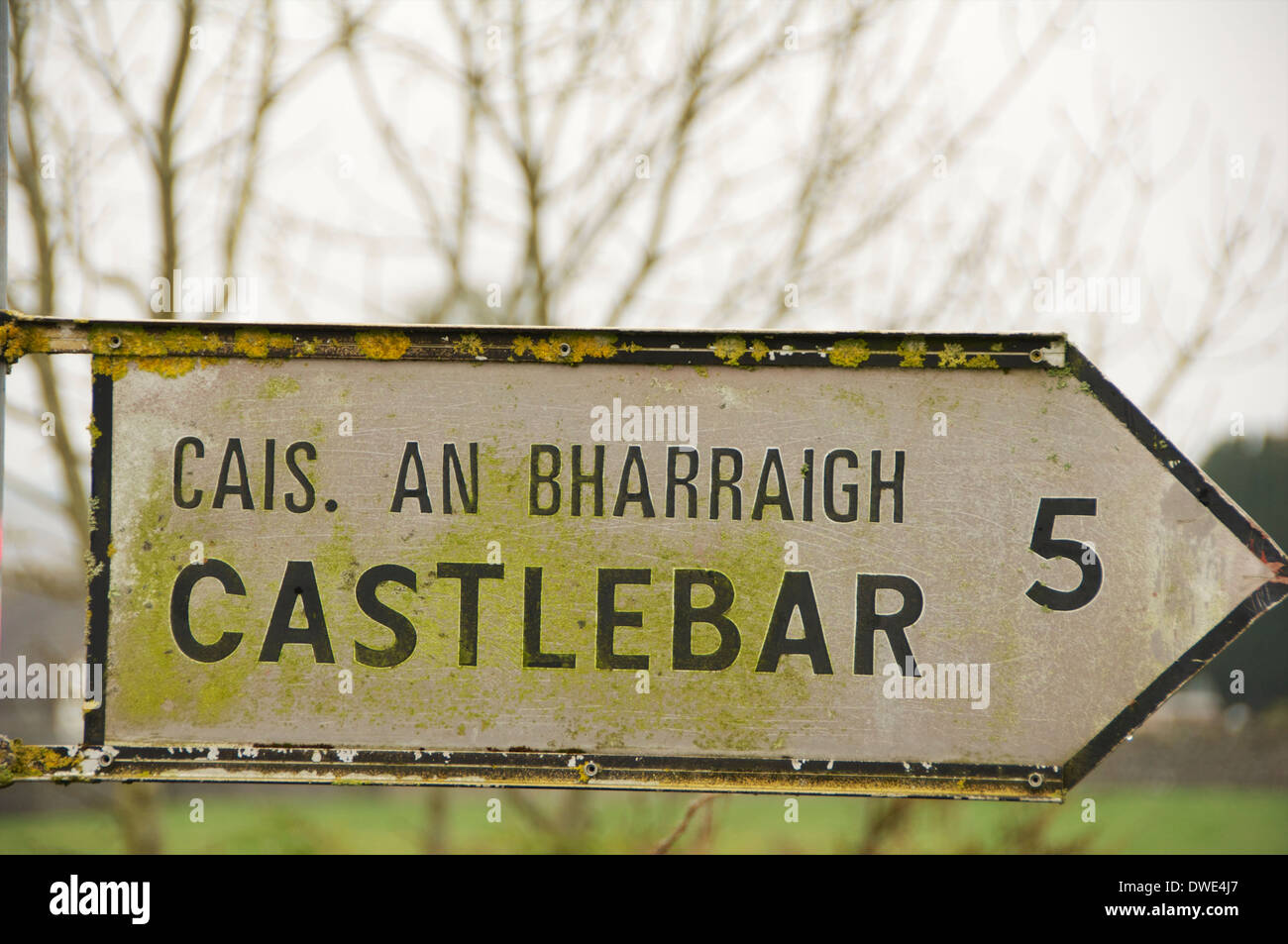 An old moss covered sign marking five miles to the town of Castlebar ...