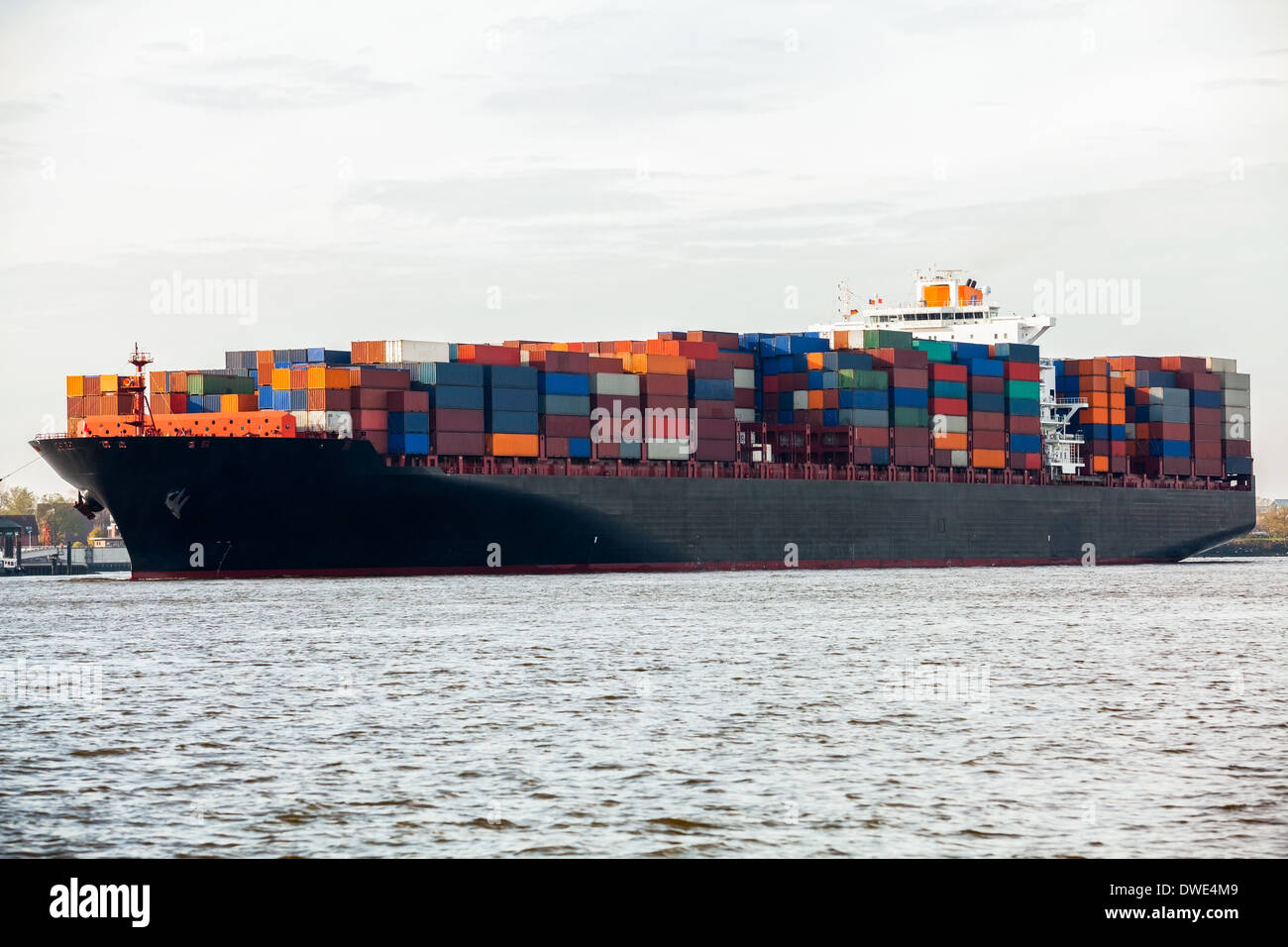 Fully laden container ship in port with its decks stacked with metal ...