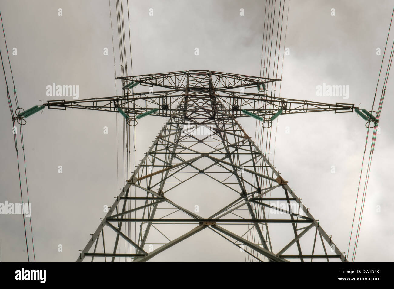 front geometrical view of a high voltage pylon cloudy sky background ...