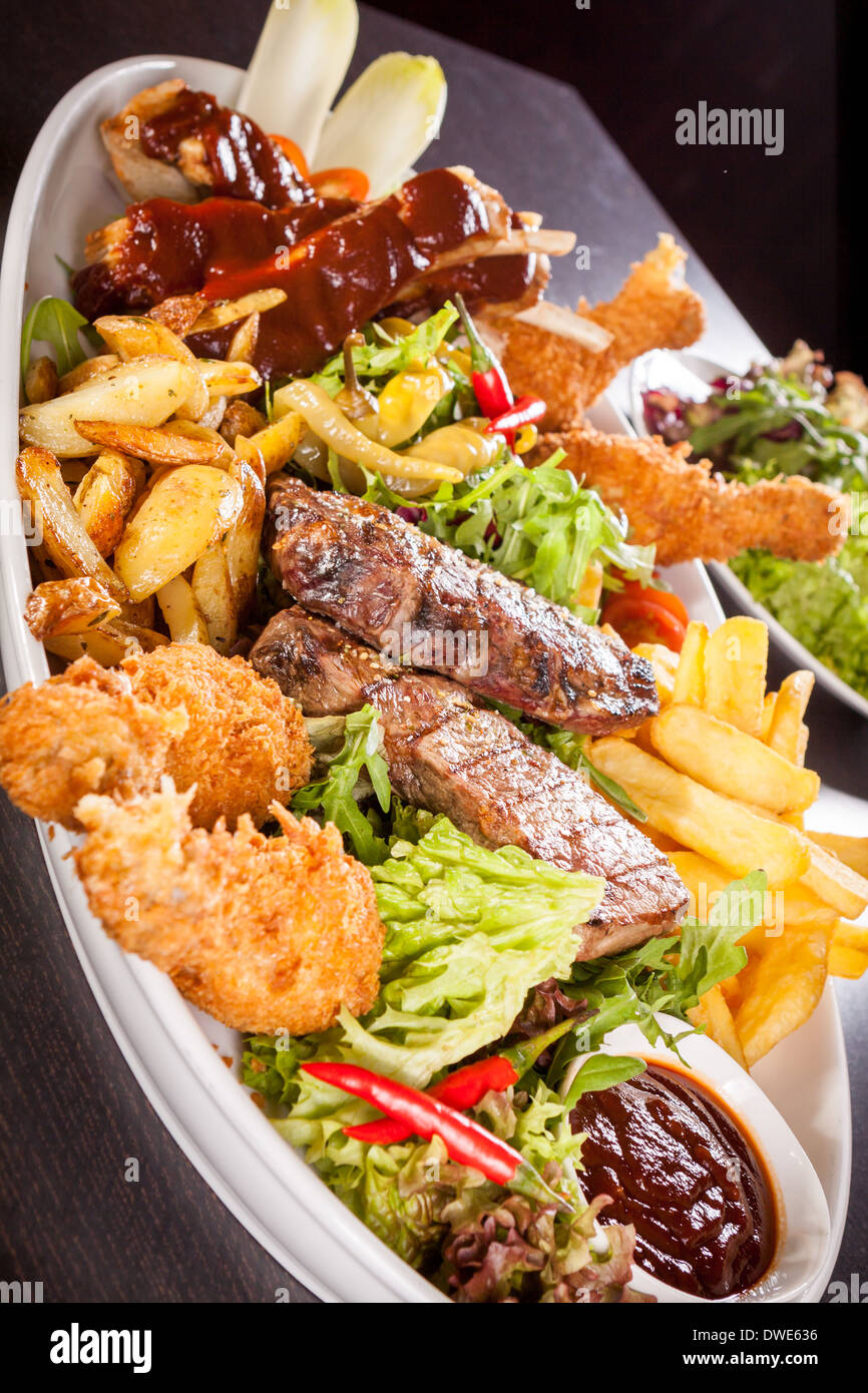 Wholesome platter of mixed meats including grilled steak, crispy ...