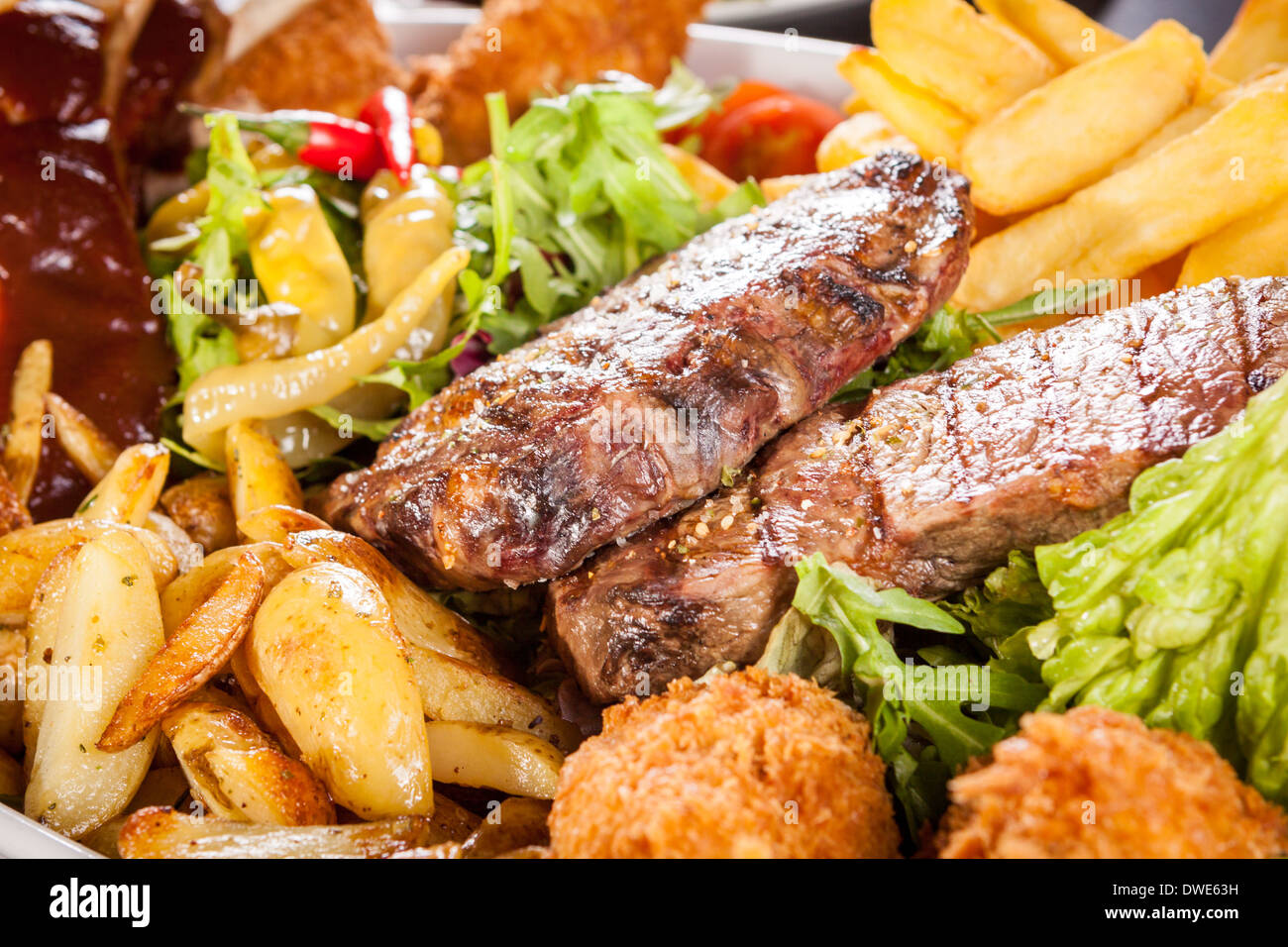 Wholesome platter of mixed meats including grilled steak, crispy ...
