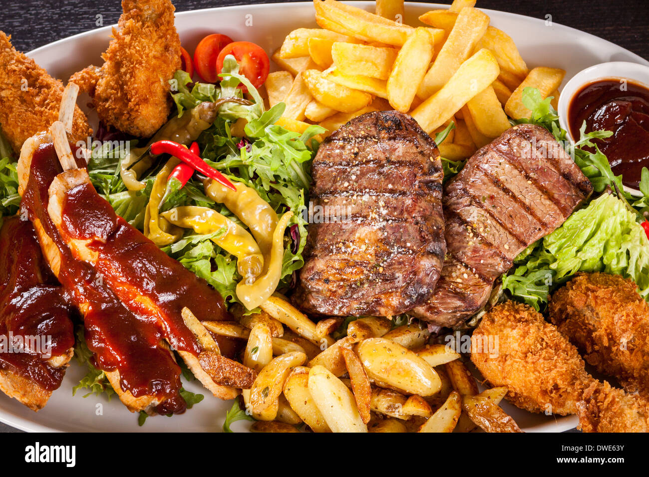 Wholesome platter of mixed meats including grilled steak, crispy ...