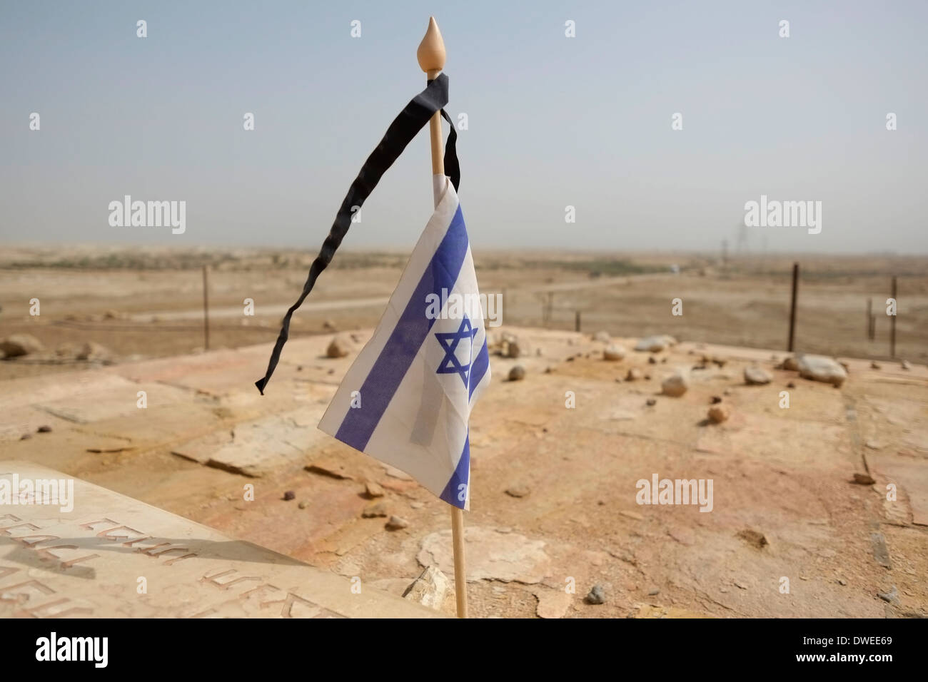 The Israeli flag with black ribbon stands at a memorial site near ...
