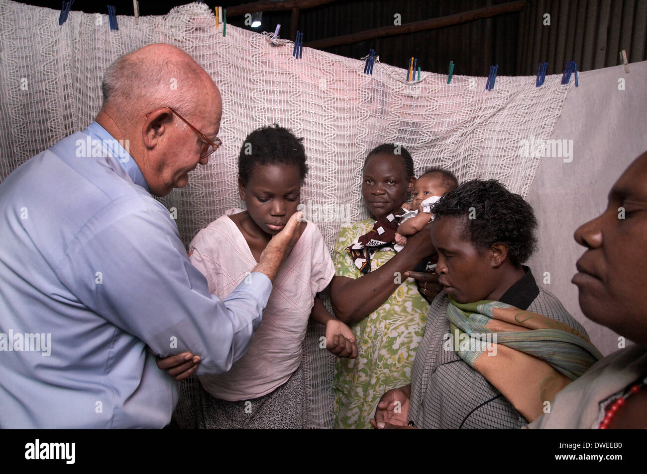 KENYA American Catholic missionary priest visiting the sick in a slum ...