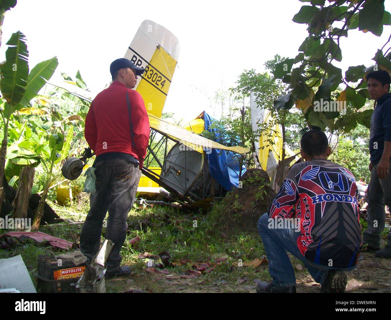 Davao City, Philippines. 7th Mar, 2014. People watch the wreckage of a ...