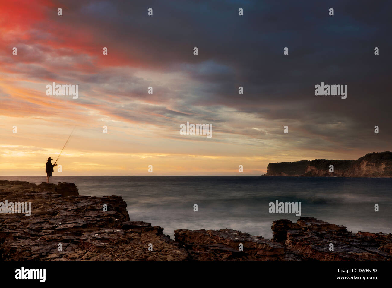A lone rock fisherman fishes at north Avoca looking towards the cliff ...