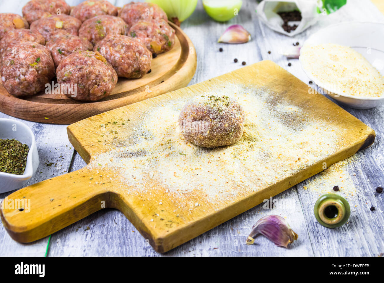 The process of rolling raw meatballs in breadcrumbs Stock Photo - Alamy