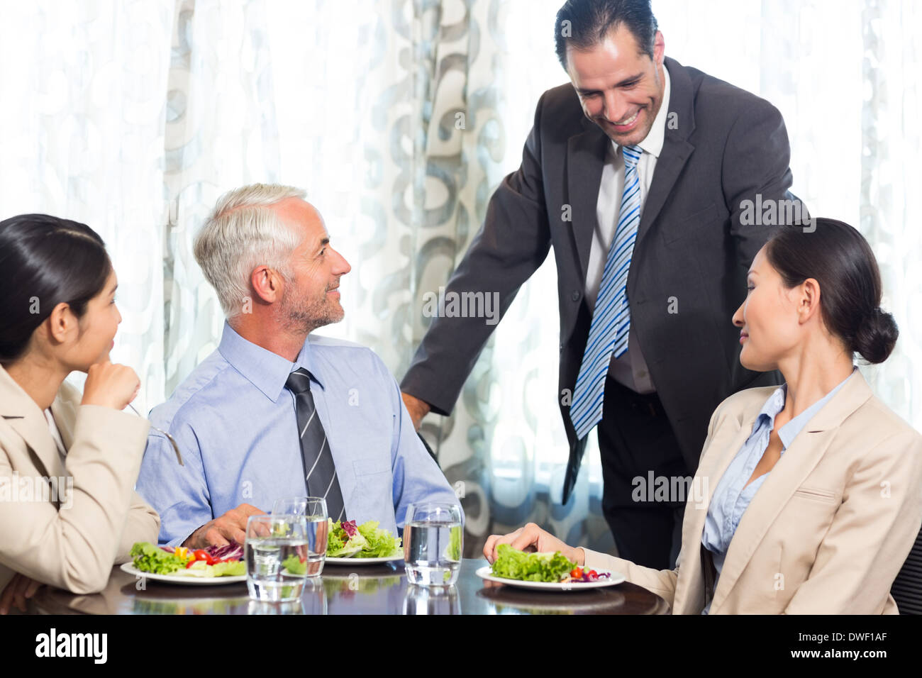 Business colleagues having meal together Stock Photo - Alamy