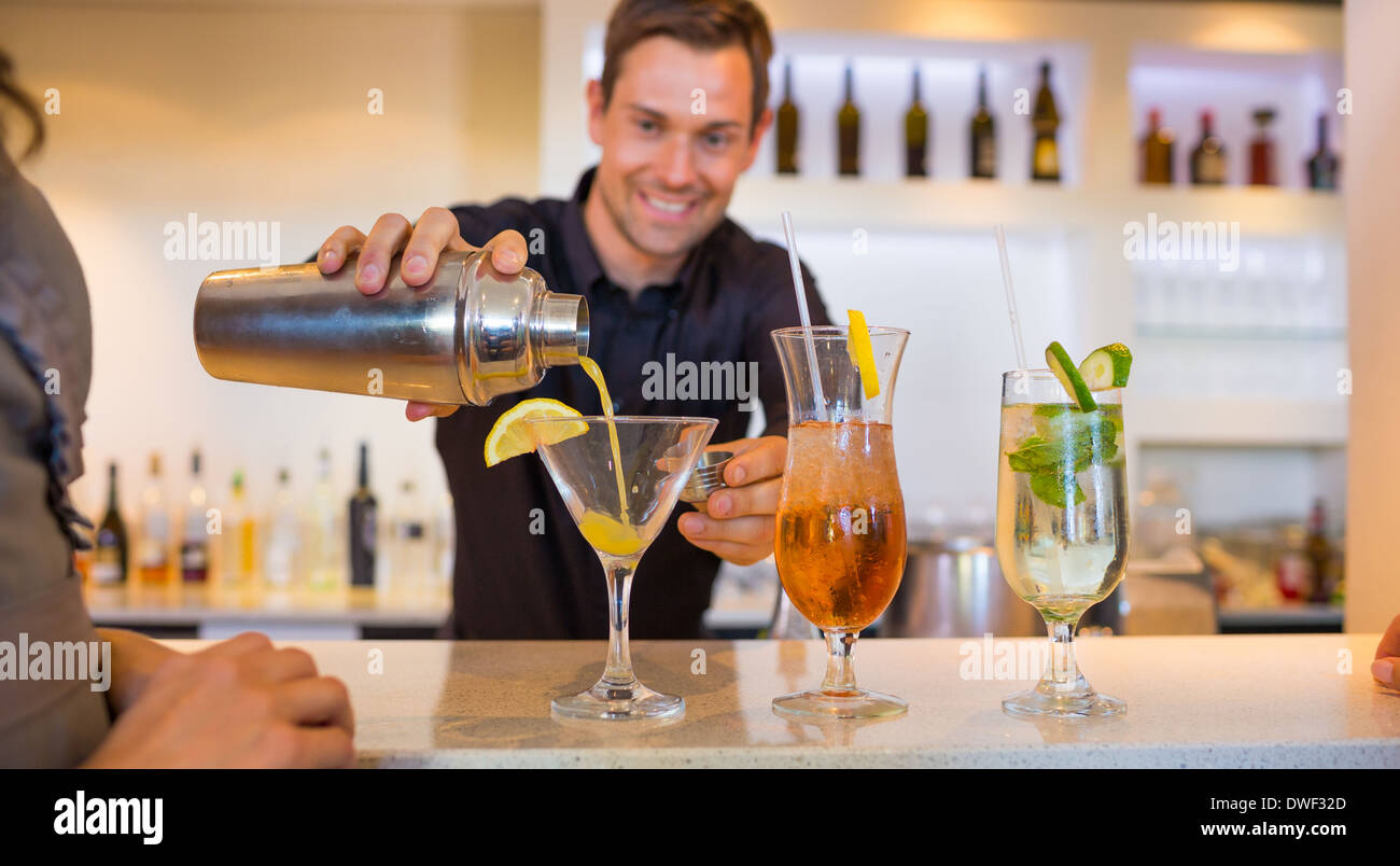 Smiling bartender preparing a drink at bar counter Stock Photo - Alamy