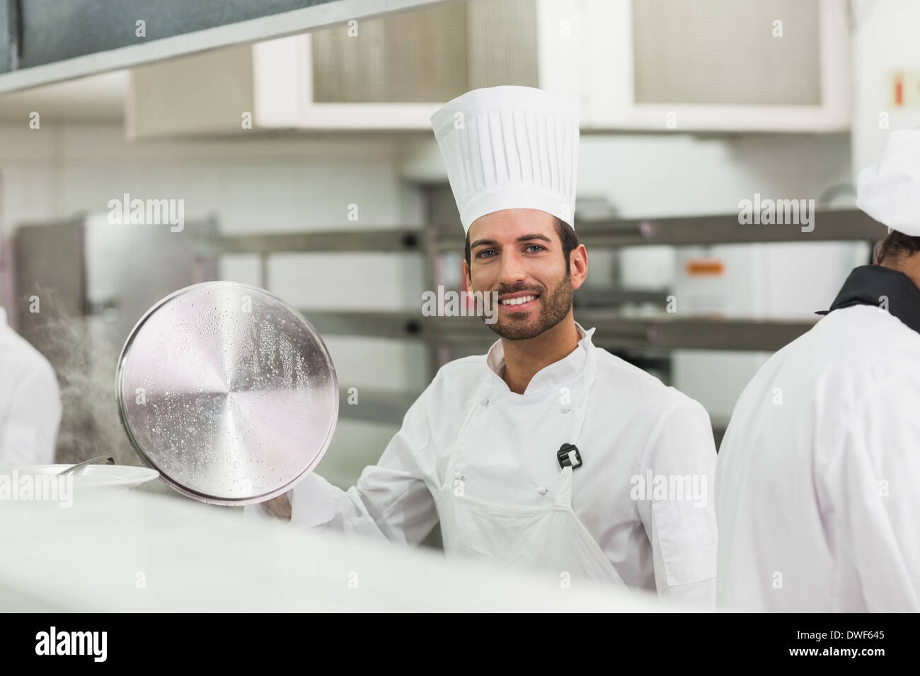 Happy chef lifting a lid off a pot Stock Photo - Alamy