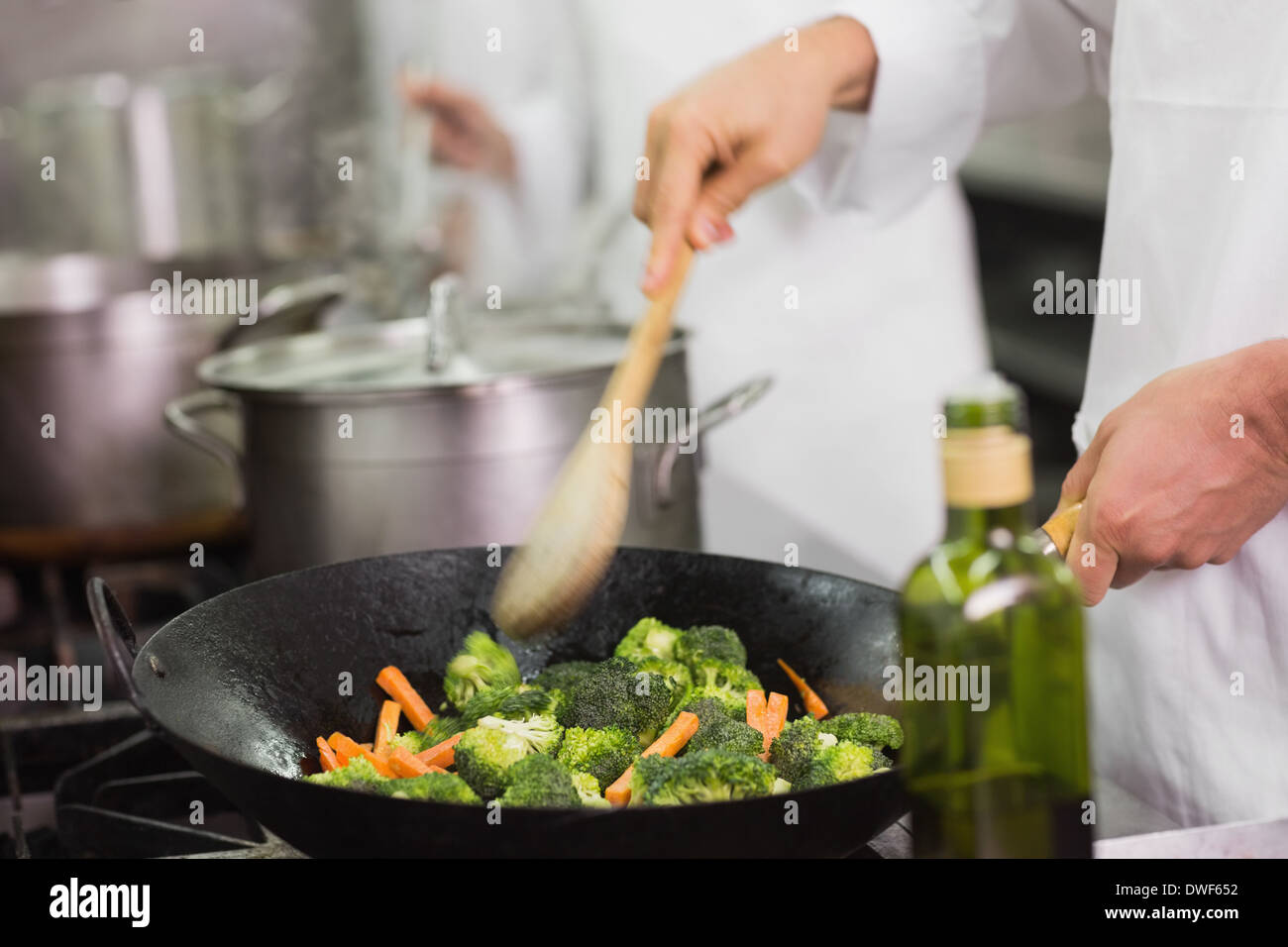 Chef frying broccoli in a wok in a commercial kitchen Stock Photo - Alamy