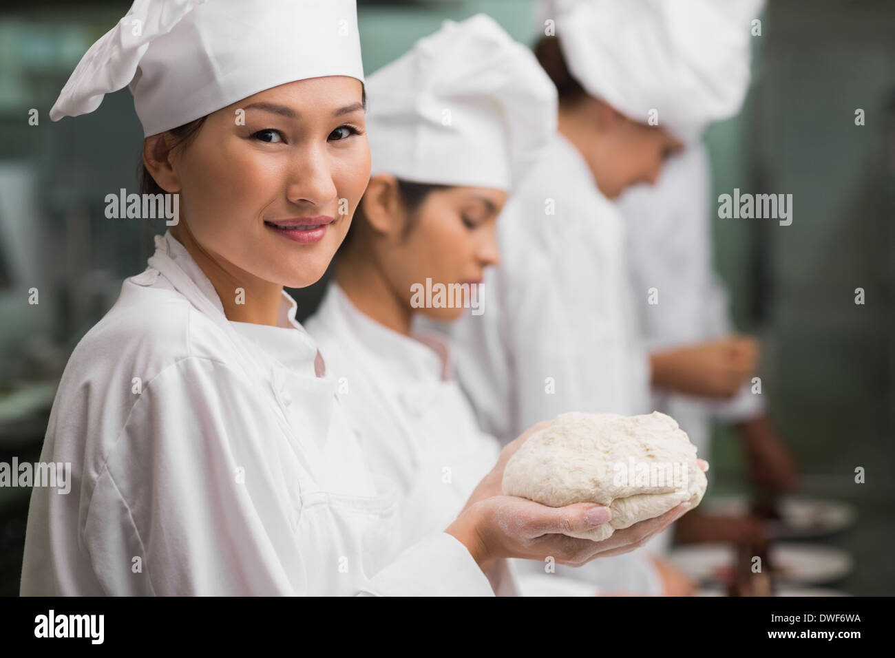 Happy chef holding dough smiling at camera Stock Photo - Alamy