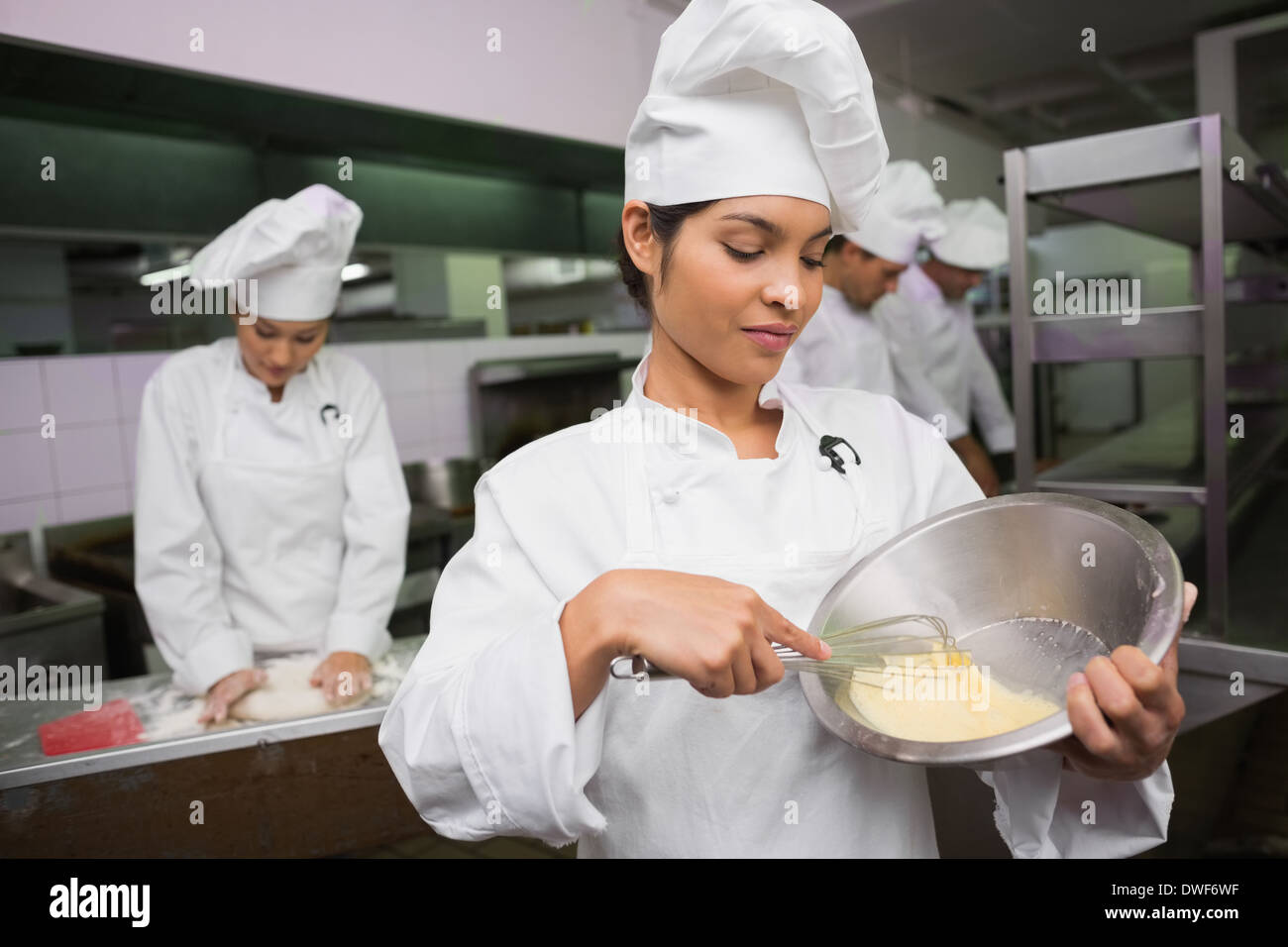 Happy chef whisking bowl of eggs Stock Photo - Alamy