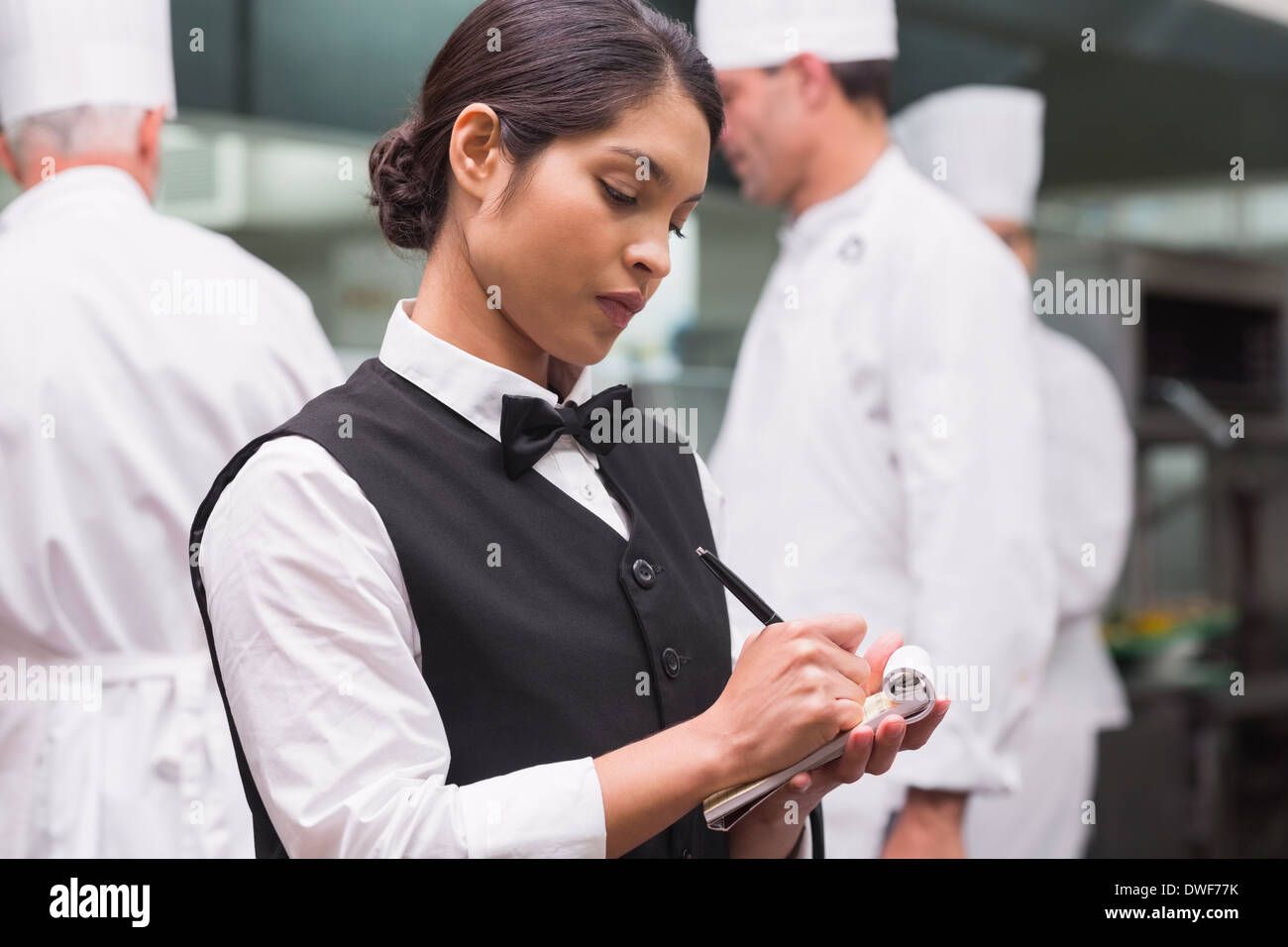 Focused waitress writing on pad Stock Photo - Alamy