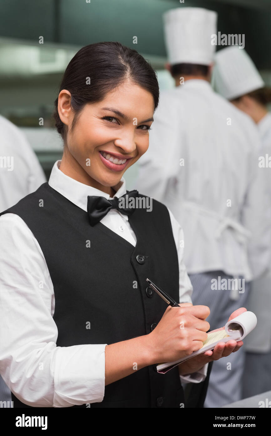 Happy waitress writing on pad Stock Photo - Alamy