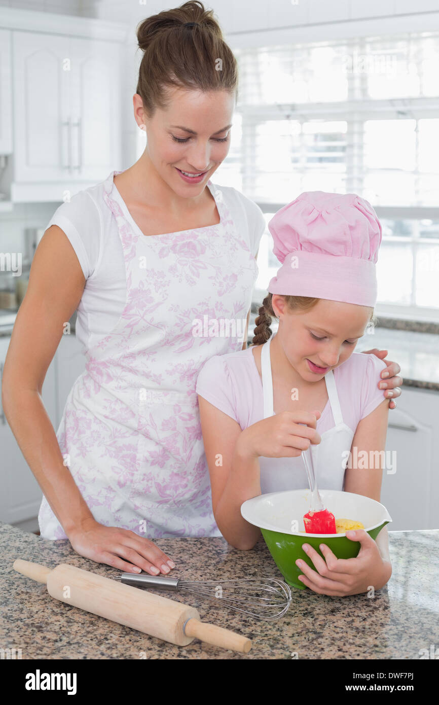 Young girl helping mother prepare food in kitchen Stock Photo - Alamy