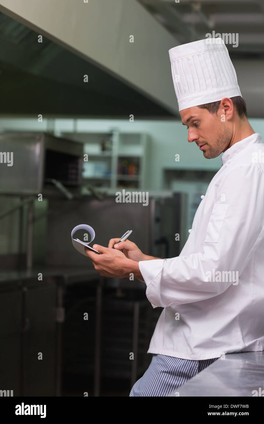 Head chef writing on clipboard Stock Photo - Alamy