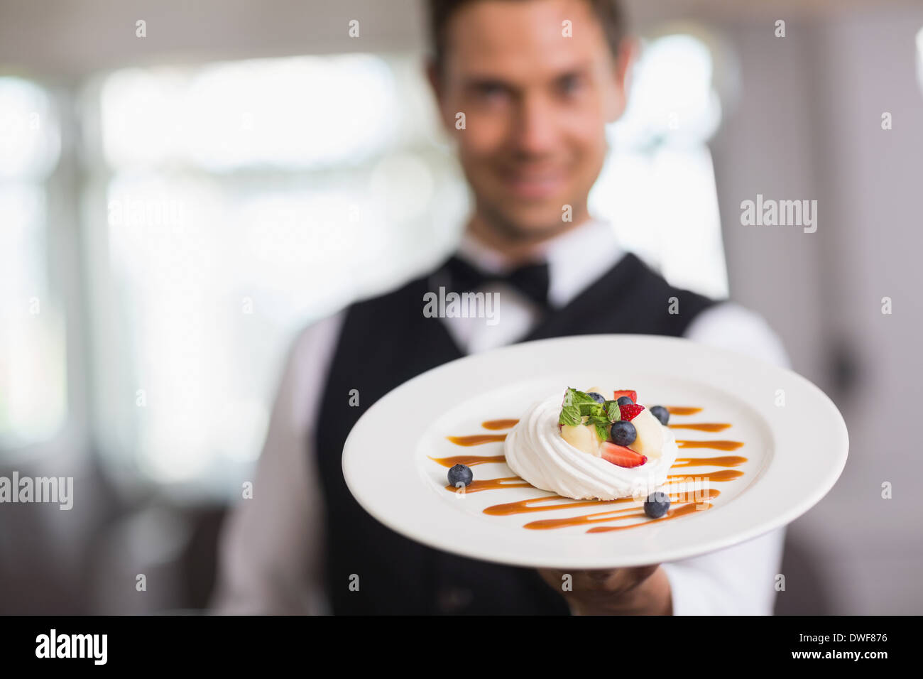Handsome waiter showing a dessert plate in a fancy restaurant Stock ...