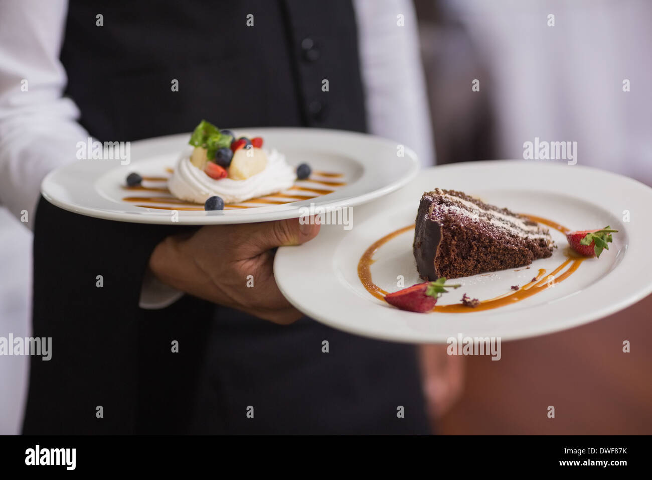 Waiter showing two dessert plates Stock Photo - Alamy