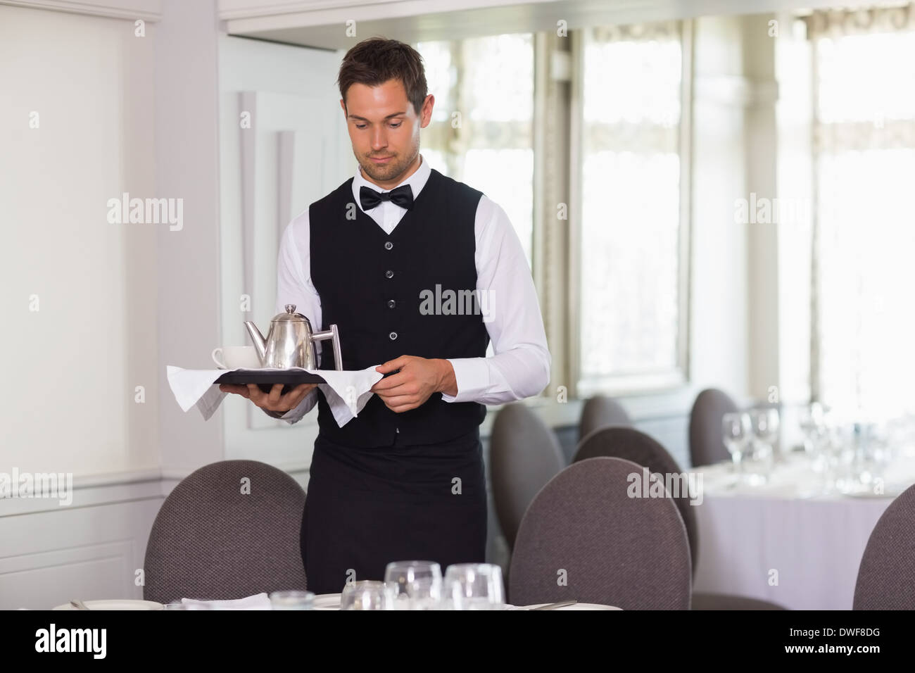 Waiter holding tray and setting table in a fancy restaurant Stock Photo ...
