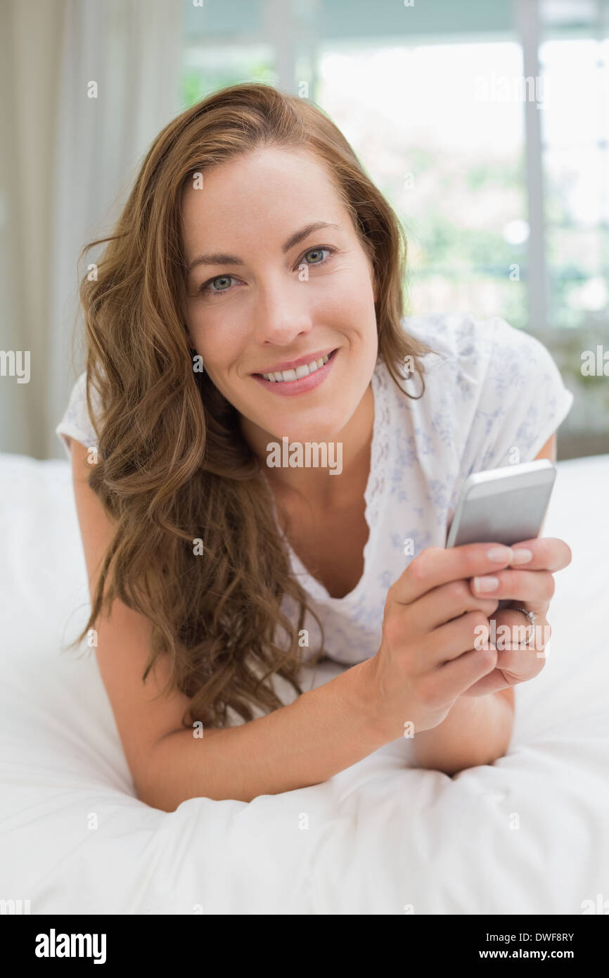 Beautiful young woman text messaging in bed Stock Photo - Alamy