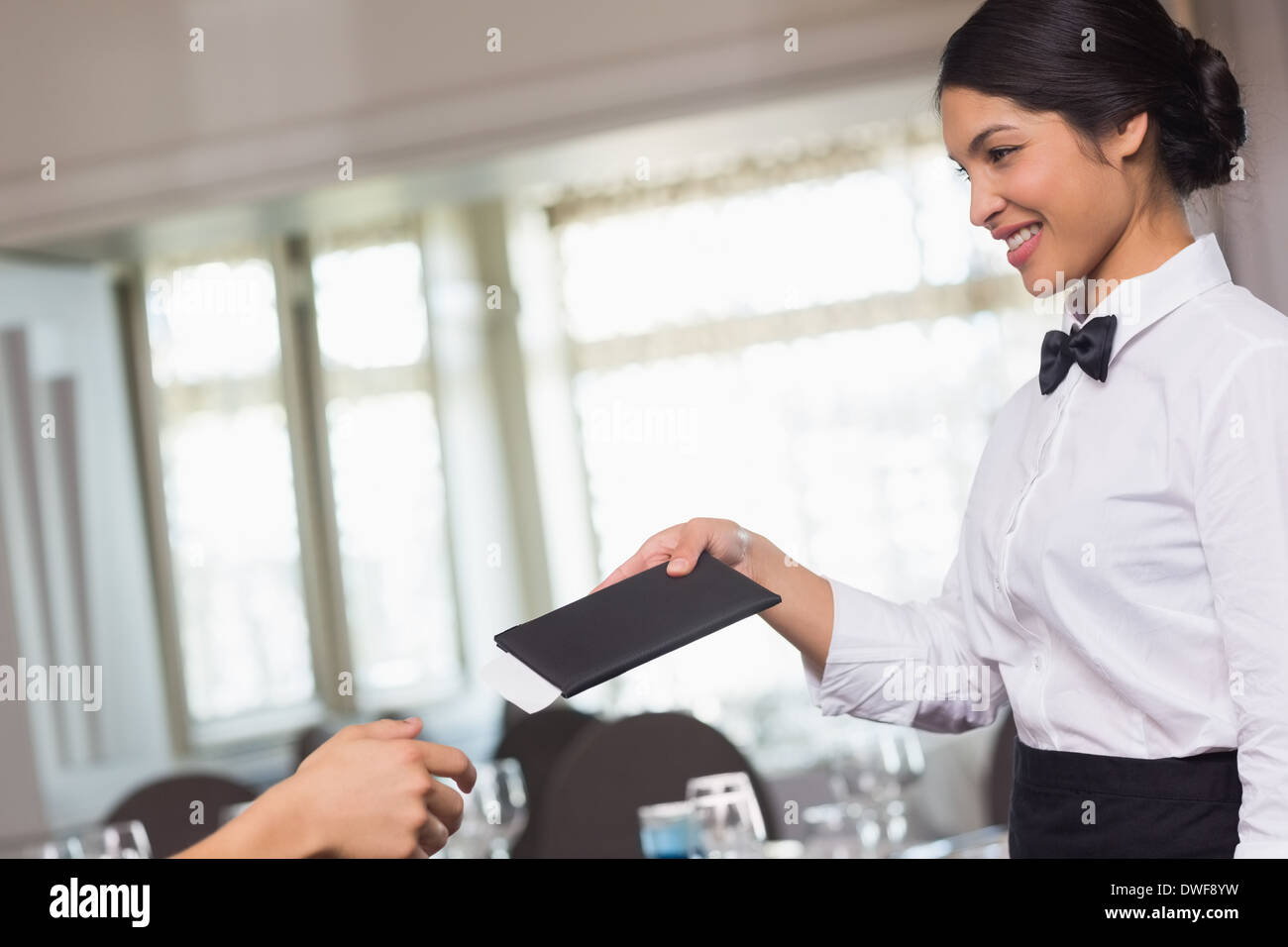 Happy waitress holding the bill Stock Photo - Alamy