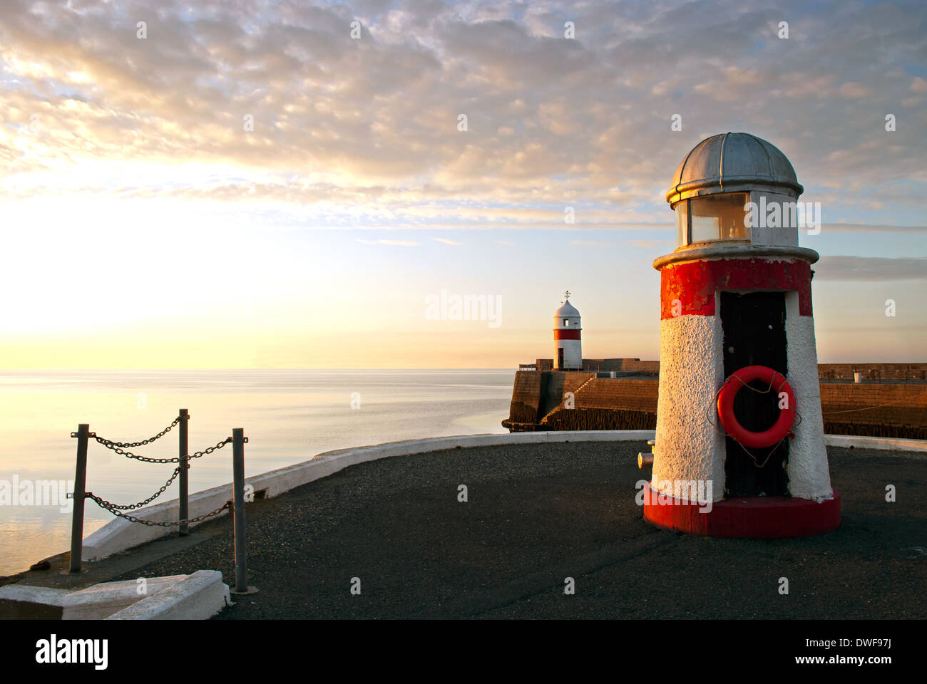 Lighthouses on breakwater wall with calm sea during sunrise. Tranquil ...