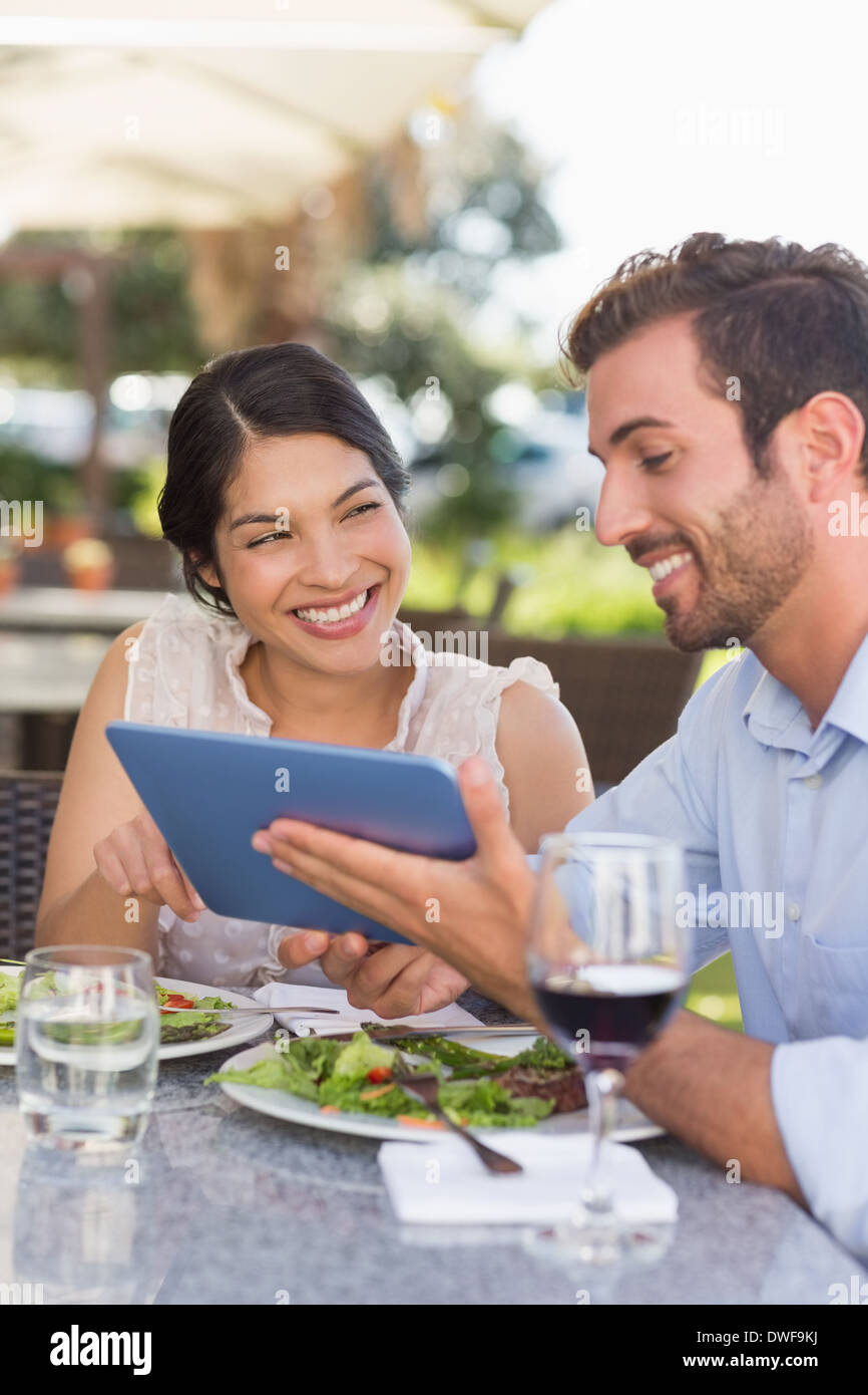 Happy couple on a date using tablet pc Stock Photo - Alamy