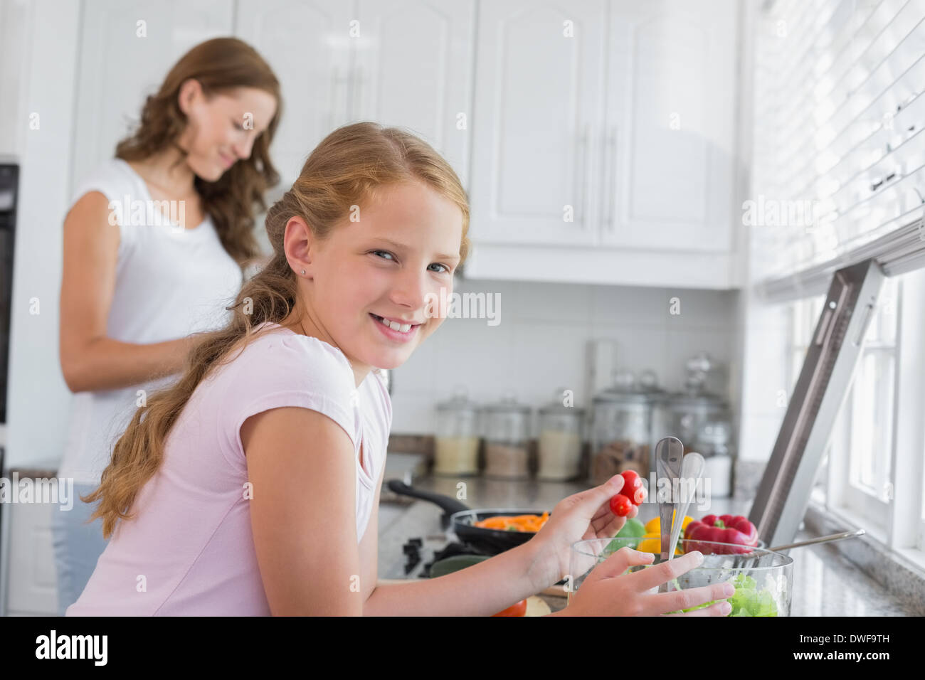 Girl helping mother to prepare food in kitchen Stock Photo - Alamy