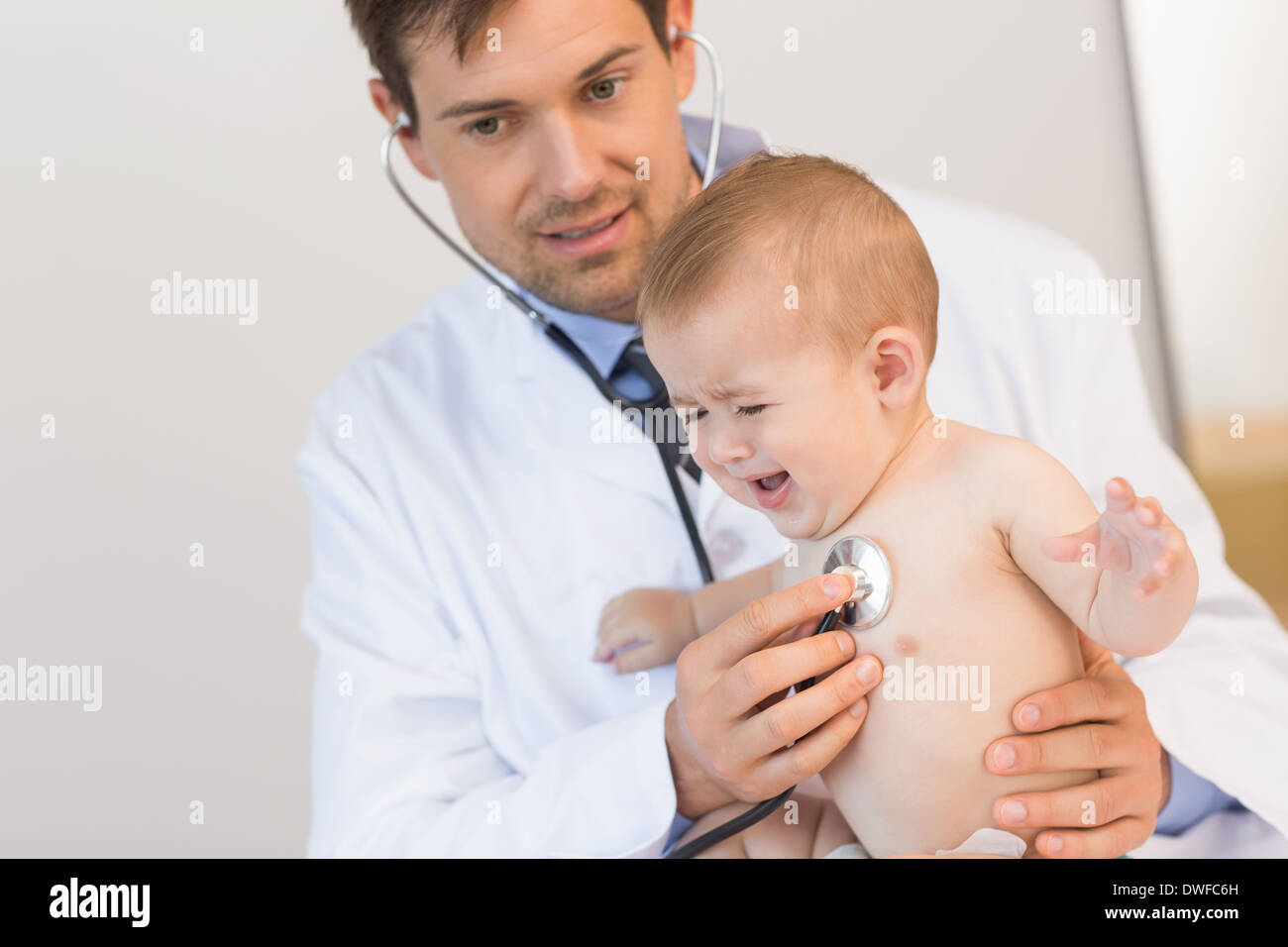 Handsome pediatrician checking baby boy Stock Photo - Alamy