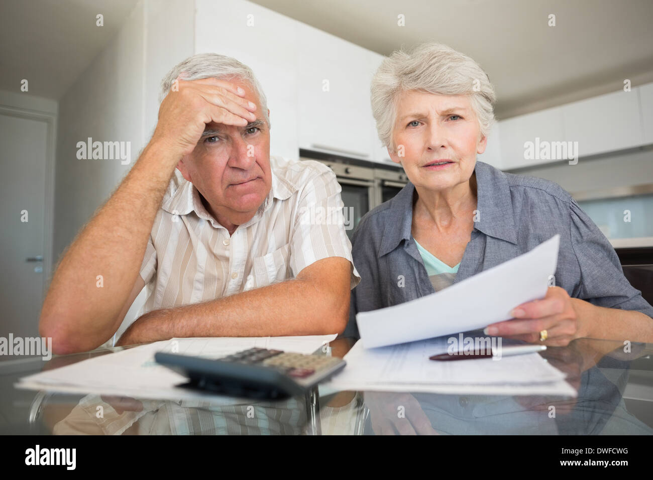 Worried couple paying their bills looking at camera Stock Photo - Alamy