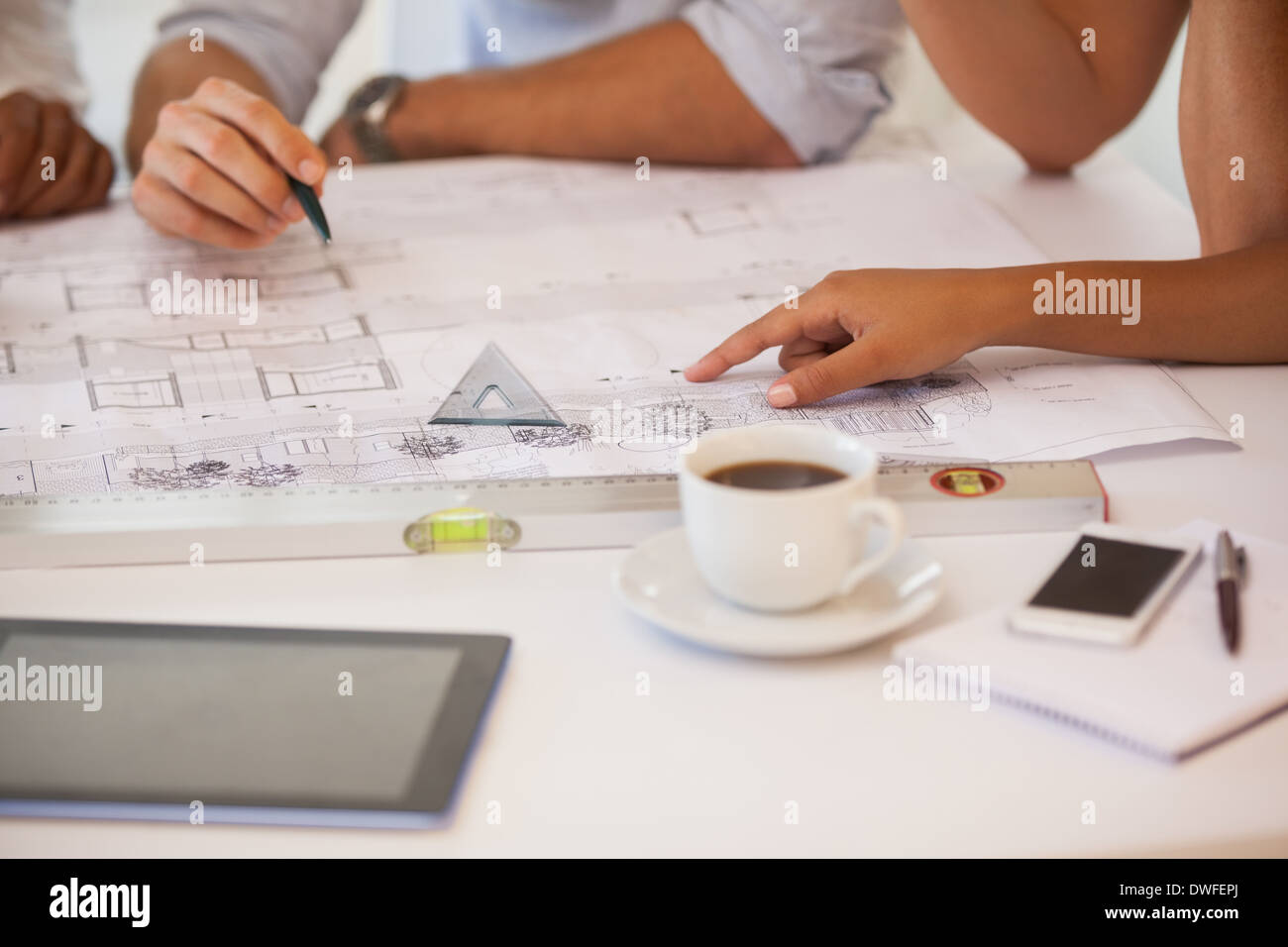Mid section of business people working on blueprints Stock Photo - Alamy