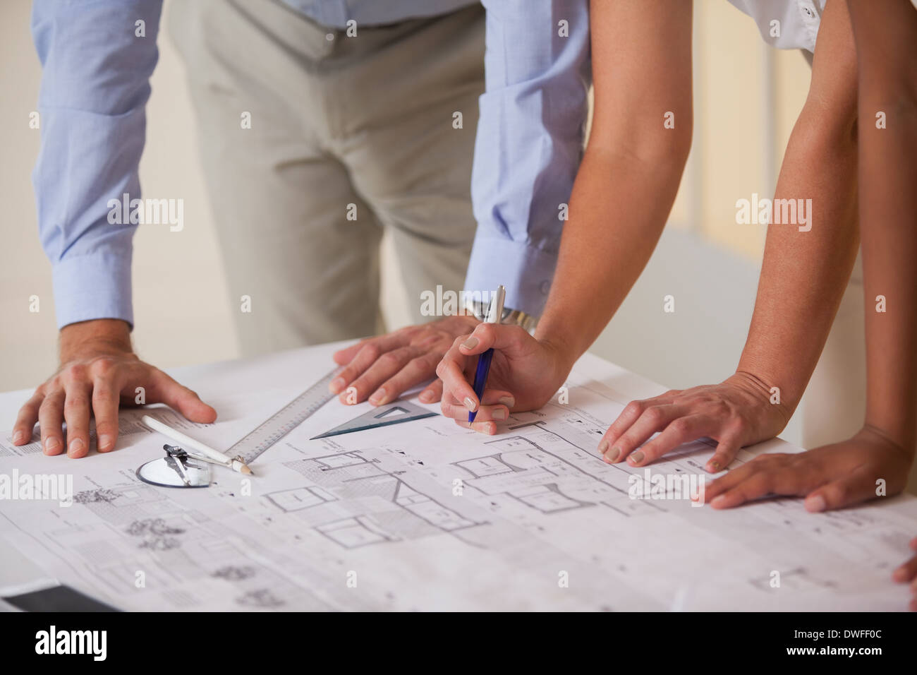 Mid section of business people working on blueprints Stock Photo - Alamy