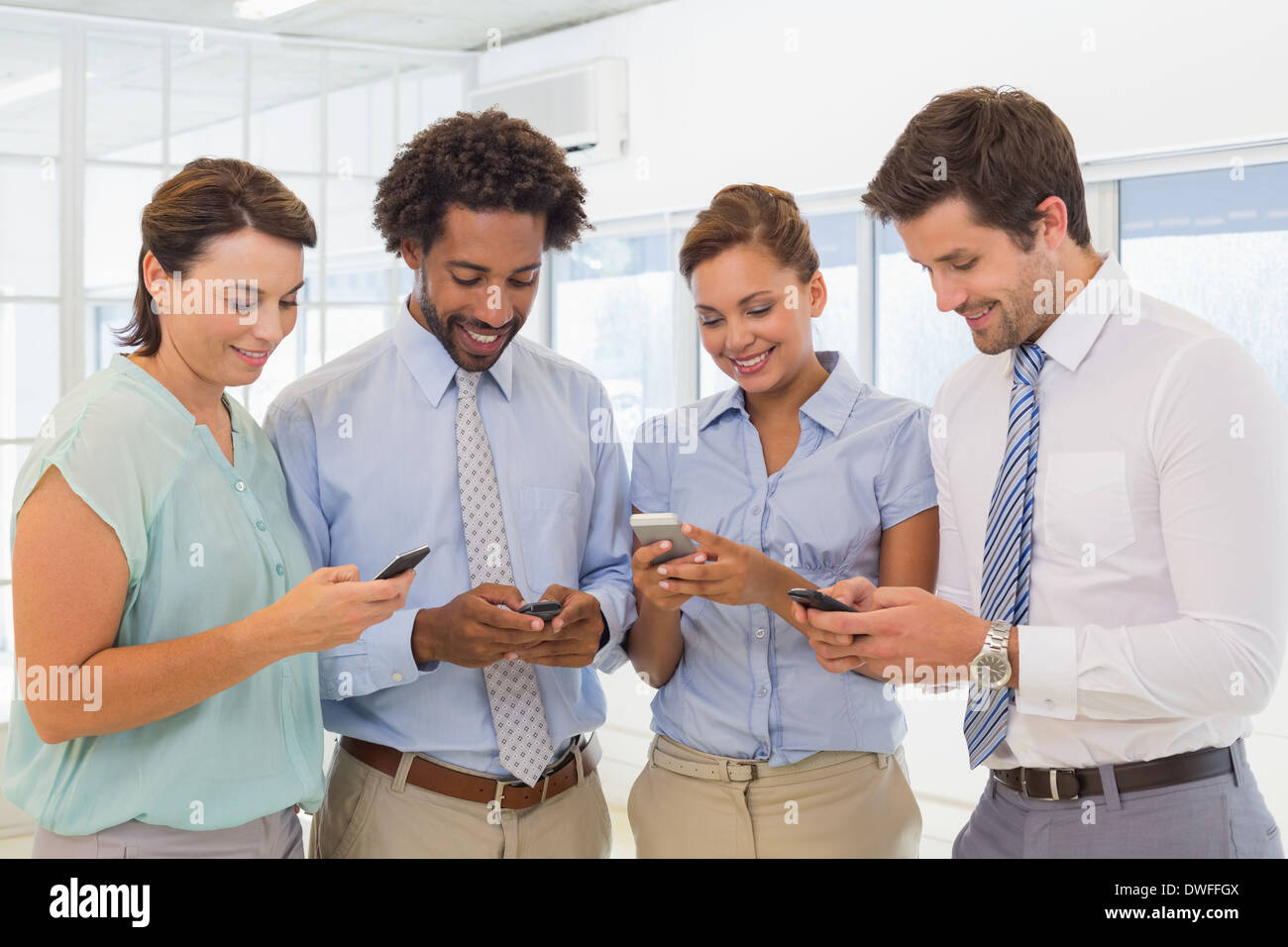 Business colleagues text messaging in office Stock Photo - Alamy