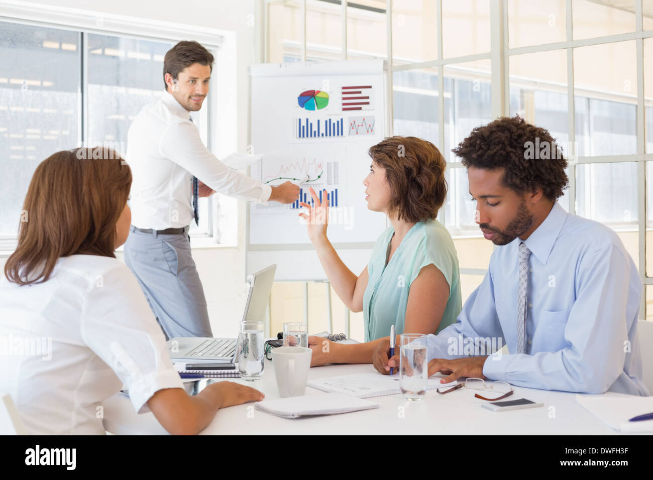 Businessman giving presentation to colleagues in office Stock Photo - Alamy