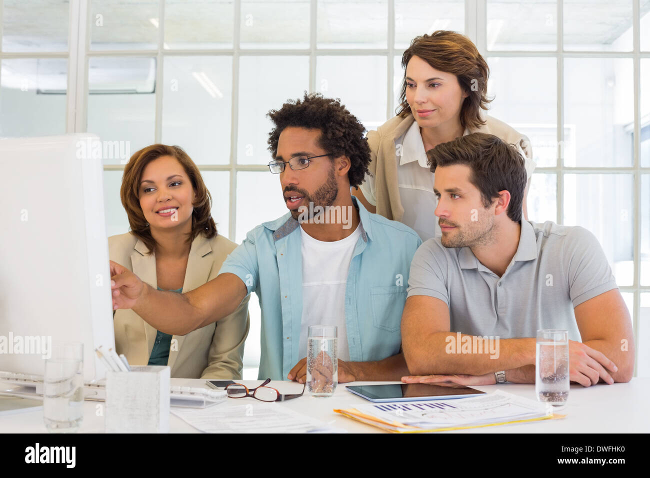 Business people using computer together at office desk Stock Photo - Alamy