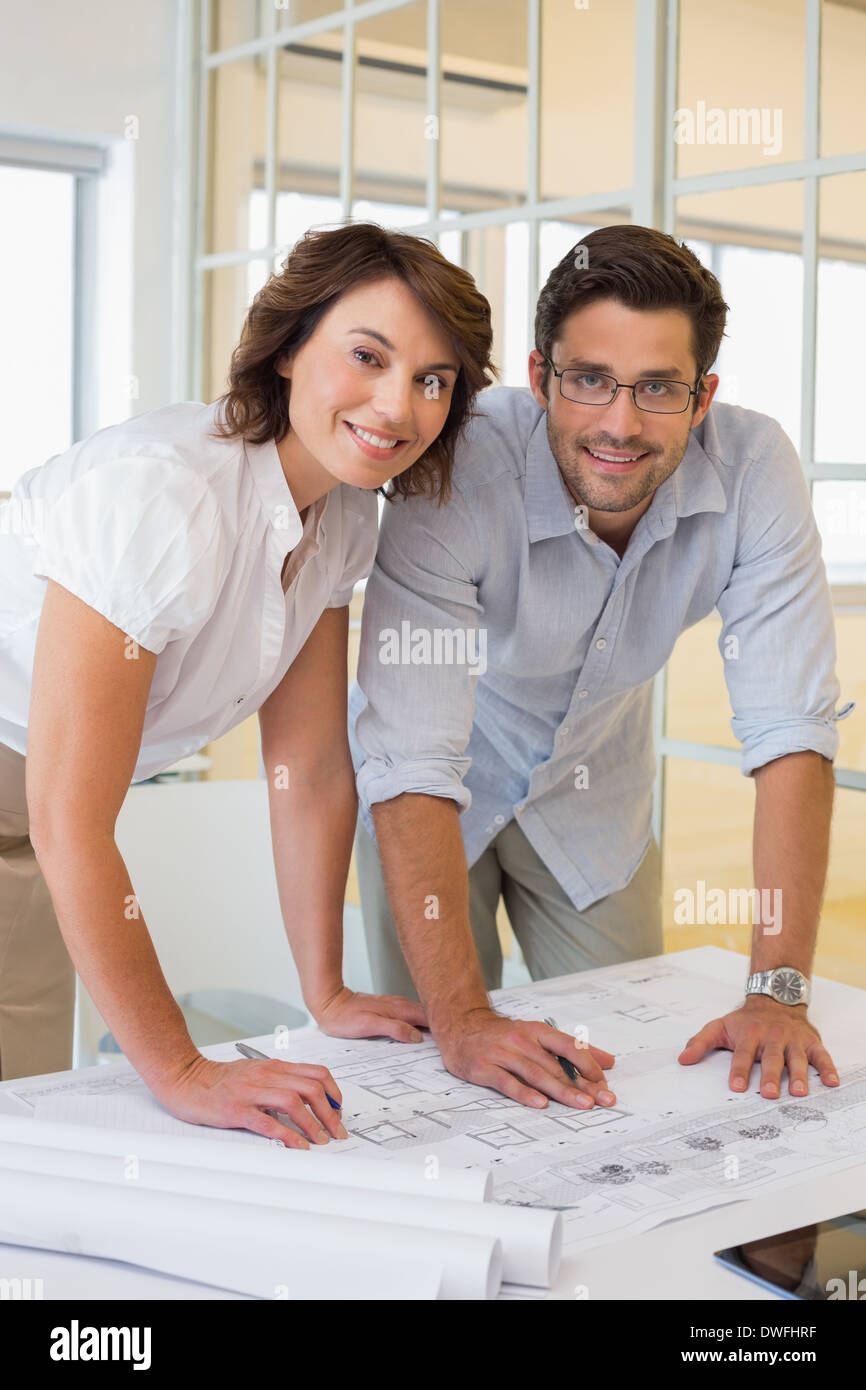 Two business people working on blueprints at office Stock Photo - Alamy
