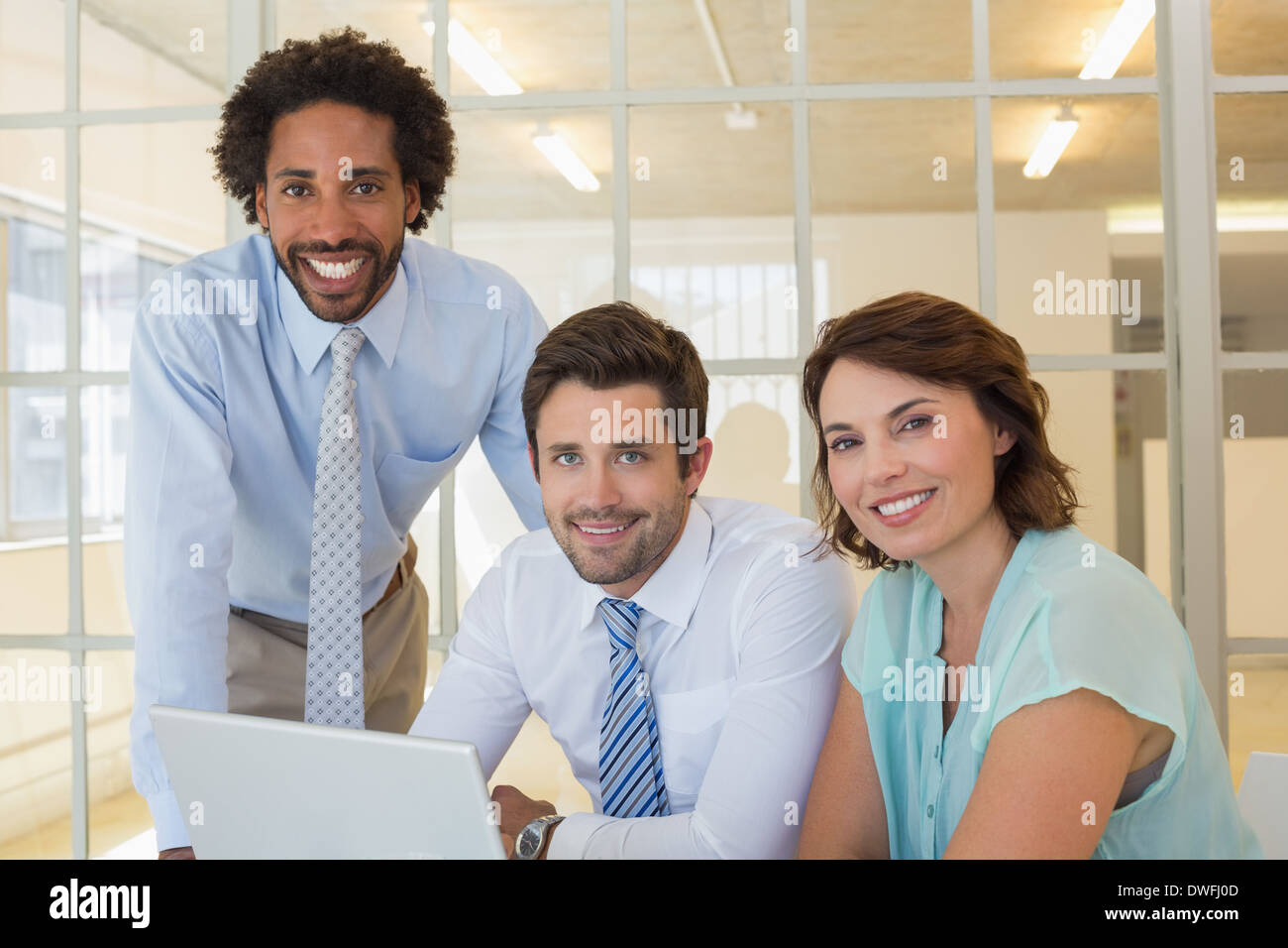 Three business people using laptop together at office Stock Photo - Alamy