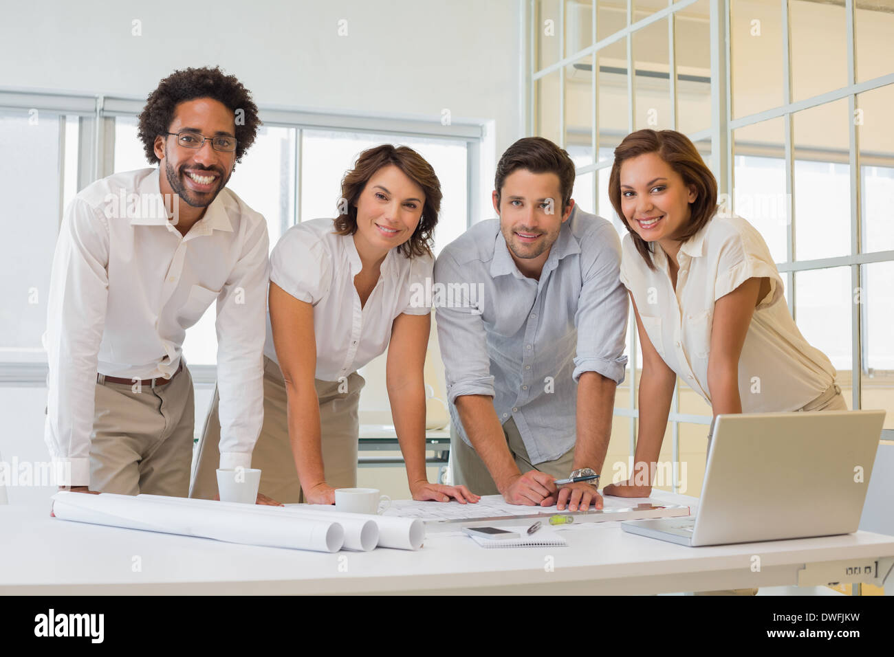 Happy business people working on blueprints at office Stock Photo - Alamy
