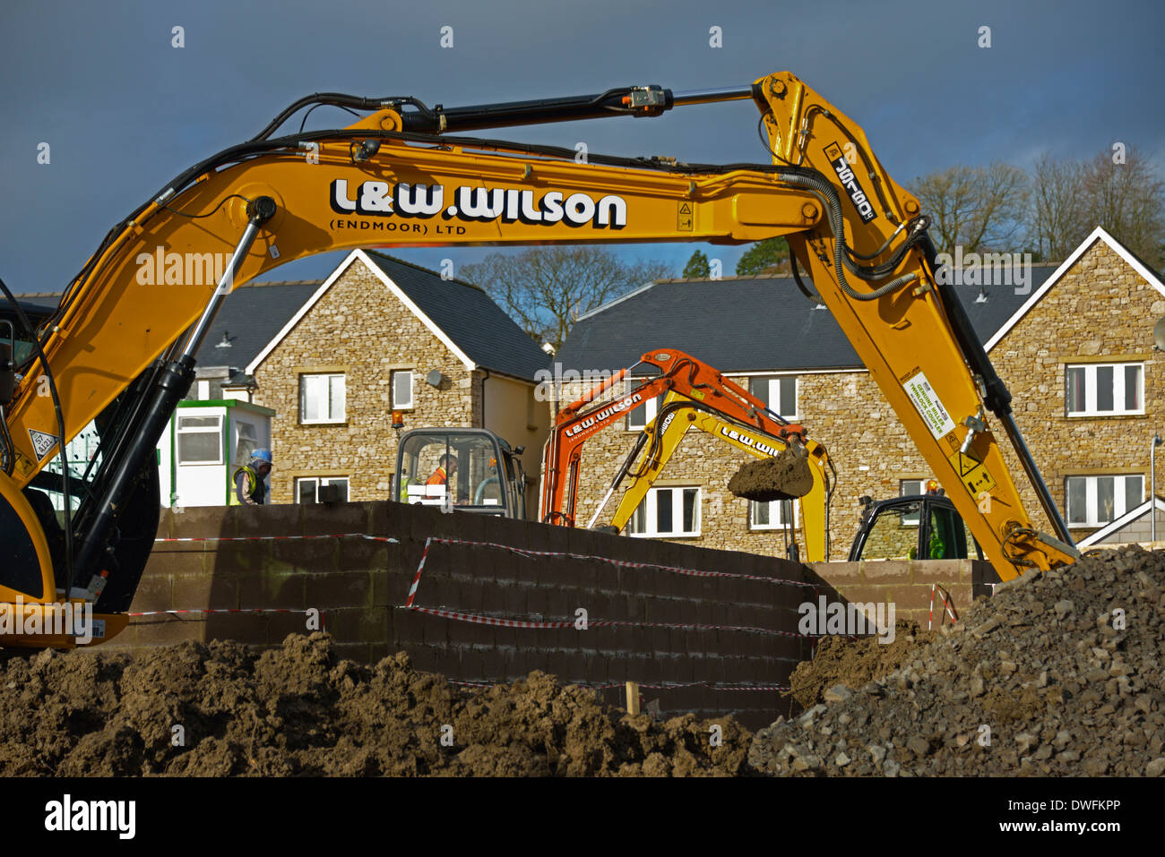 Excavators on house building site Stock Photo - Alamy
