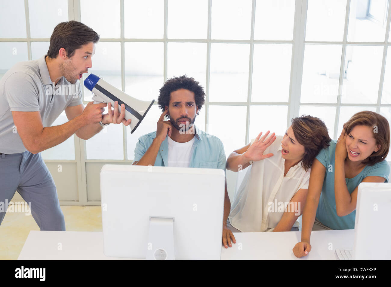 Man yelling through megaphone at business people Stock Photo - Alamy