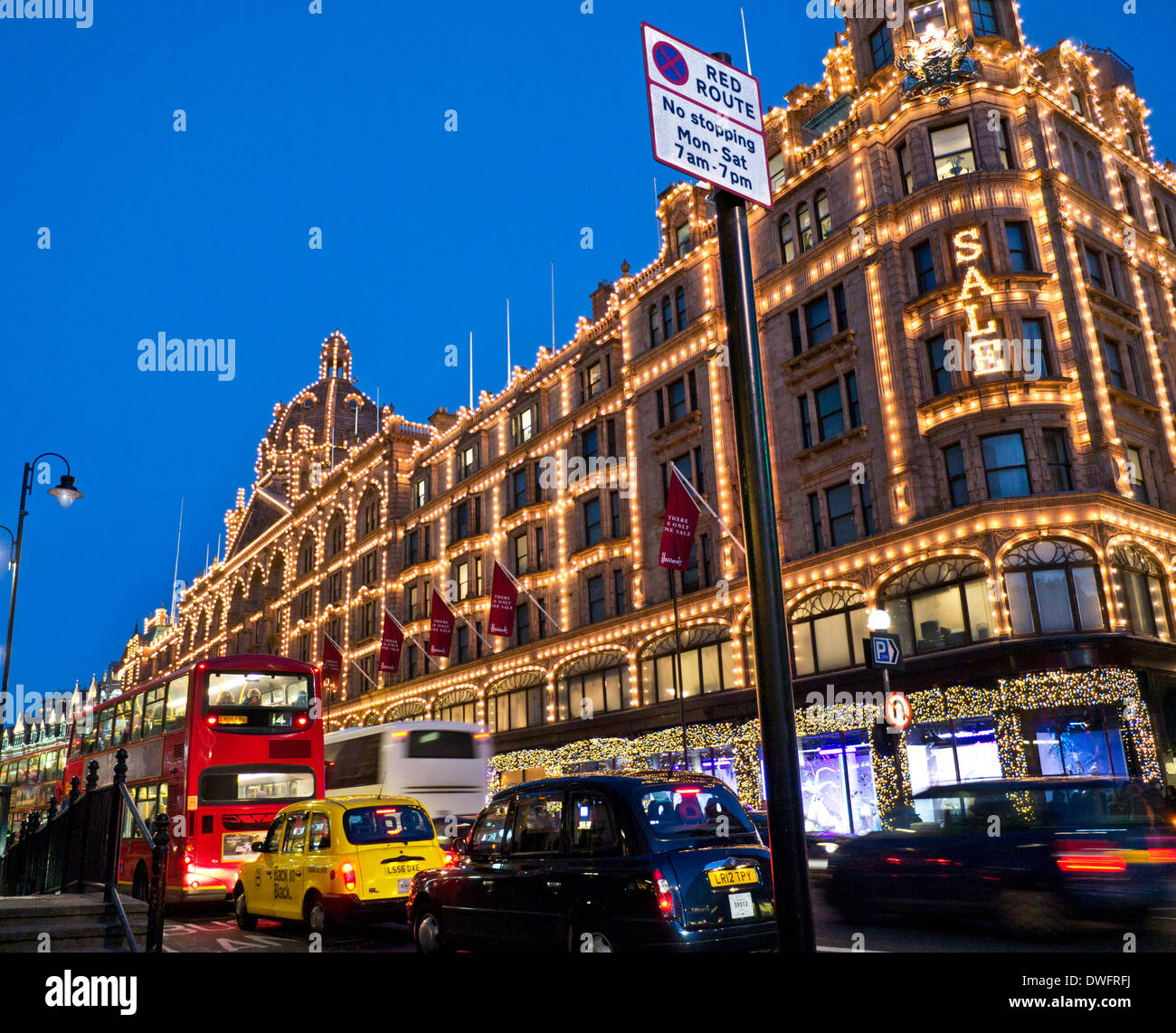 Harrods sale lights dusk department store with lit 'Sale' sign shoppers ...