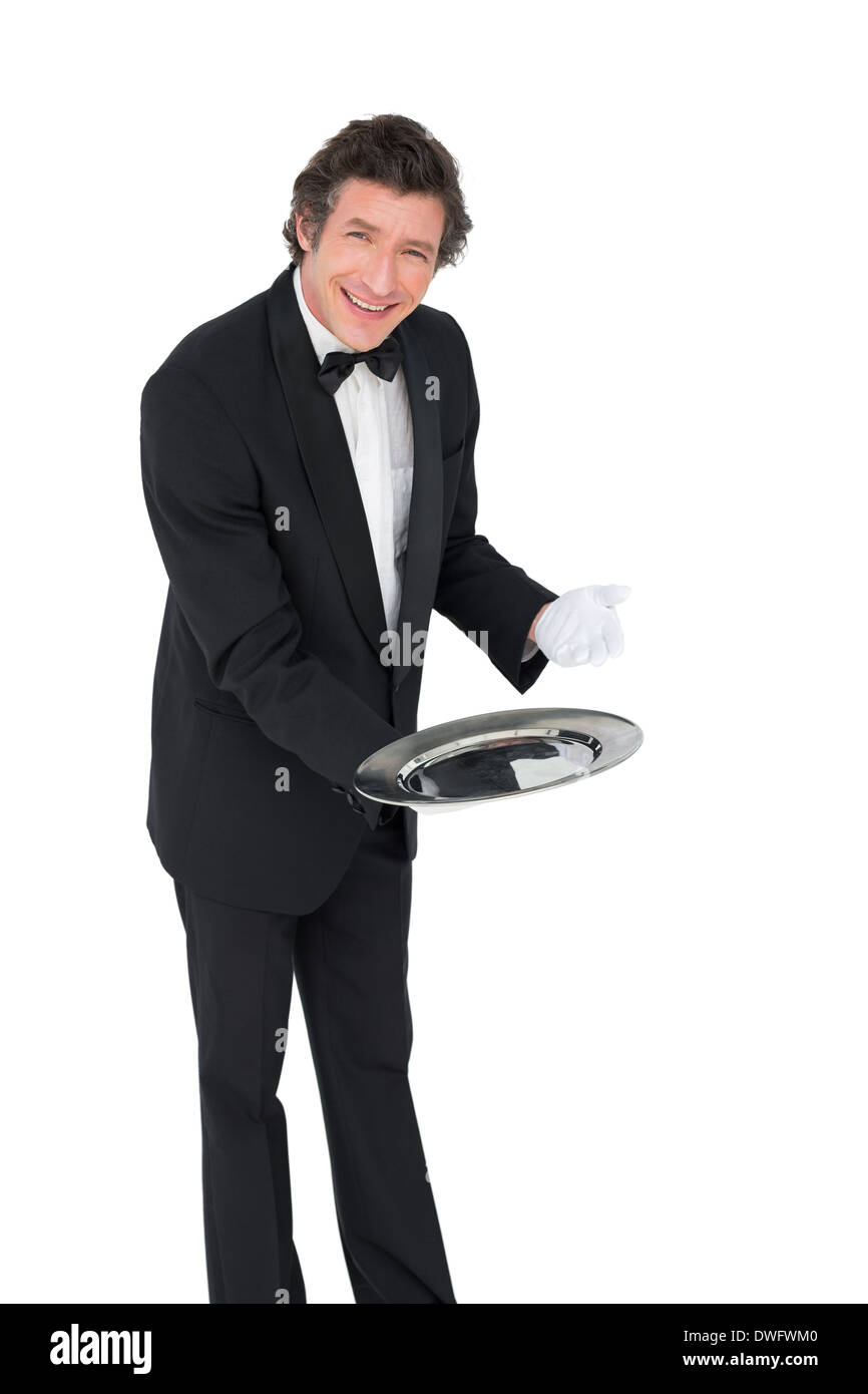 Smiling waiter showing empty tray over white background Stock Photo - Alamy