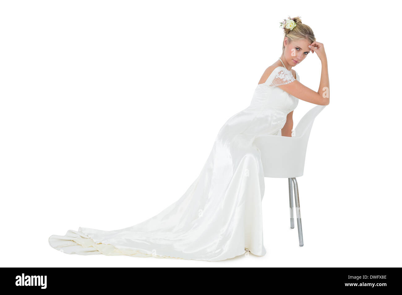 Confident bride leaning on chair over white background Stock Photo - Alamy