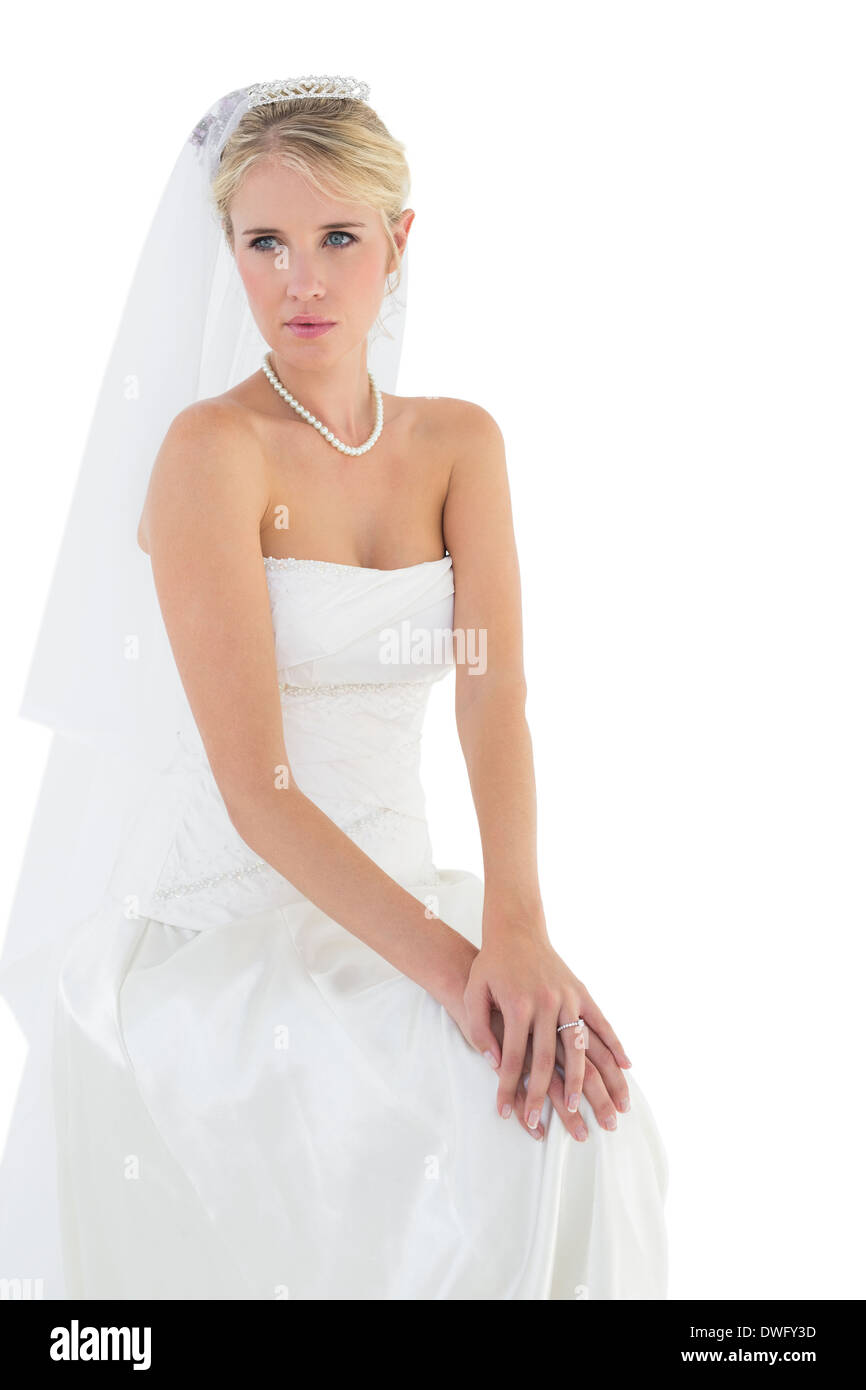 Thoughtful bride sitting against white background Stock Photo - Alamy