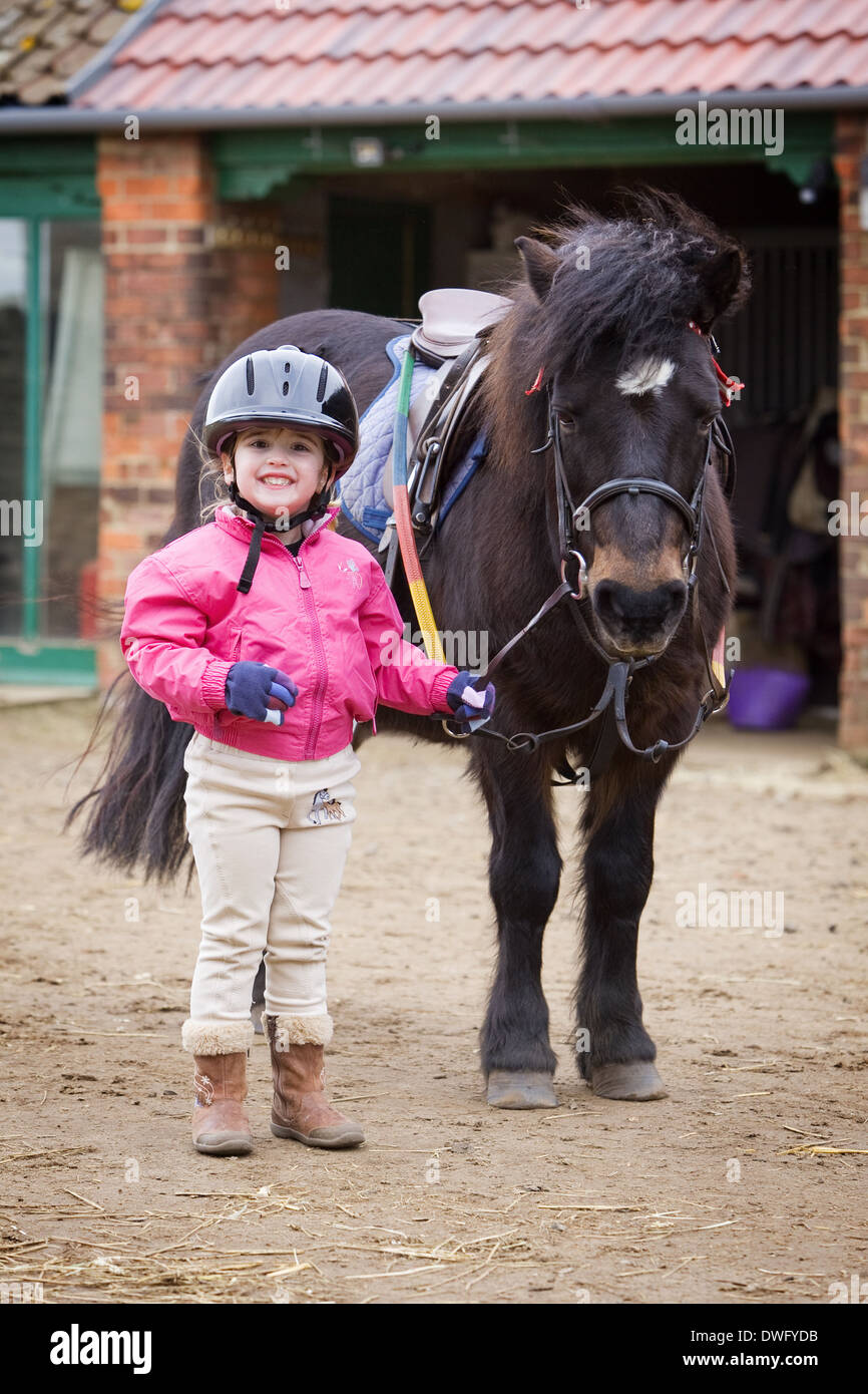 A four year old girl with a pony during a riding lesson in North ...