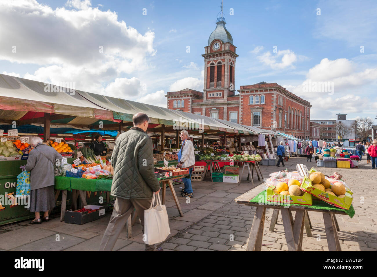 People shopping at a market stall for fruit and vegetables at ...