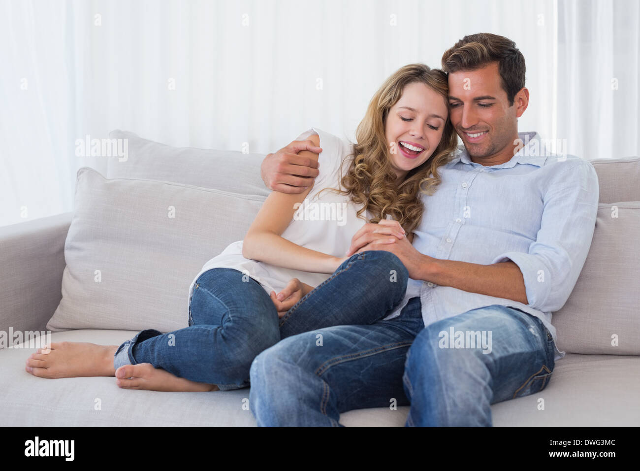 Portrait of a loving couple sitting on couch Stock Photo - Alamy