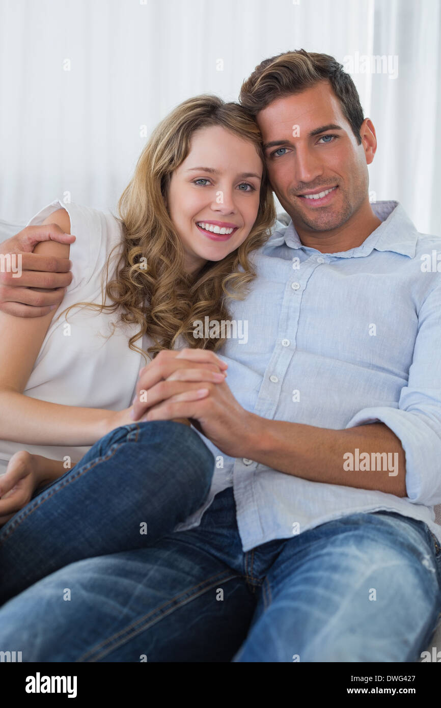 Portrait of a loving couple sitting on couch Stock Photo - Alamy