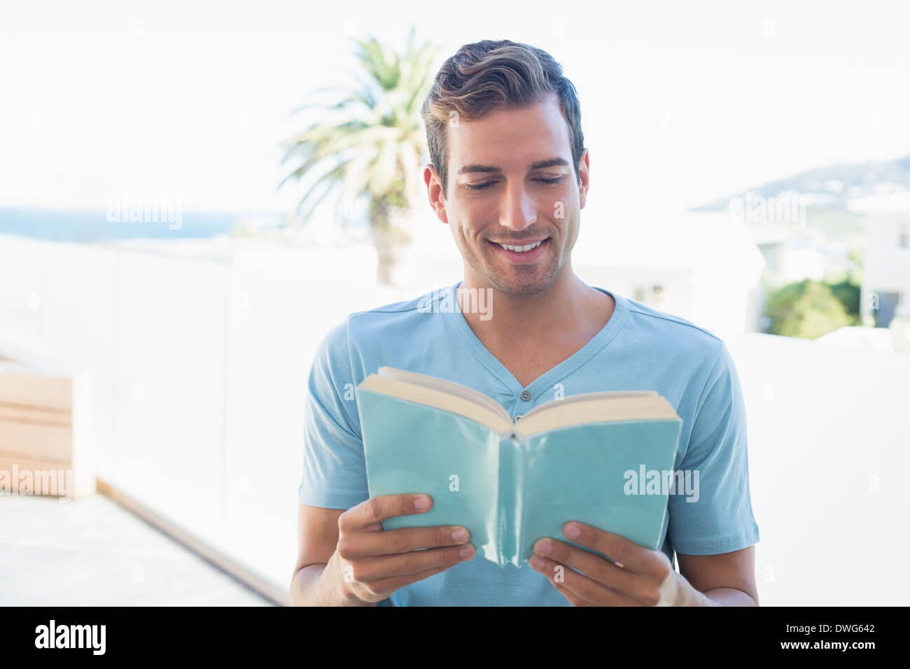 Smiling young reading book Stock Photo - Alamy